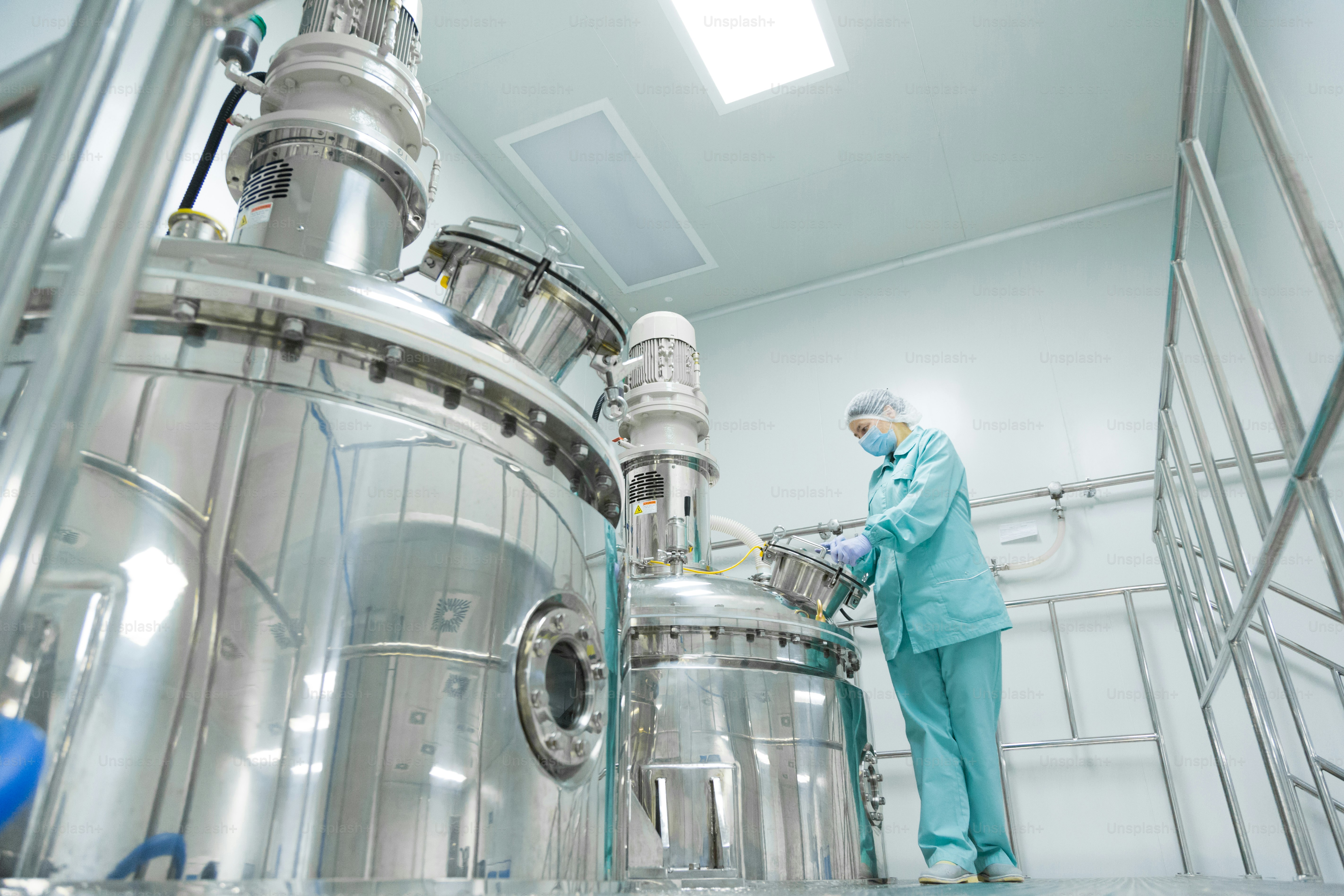 Pharmaceutical technician in sterile environment working with equipment ...