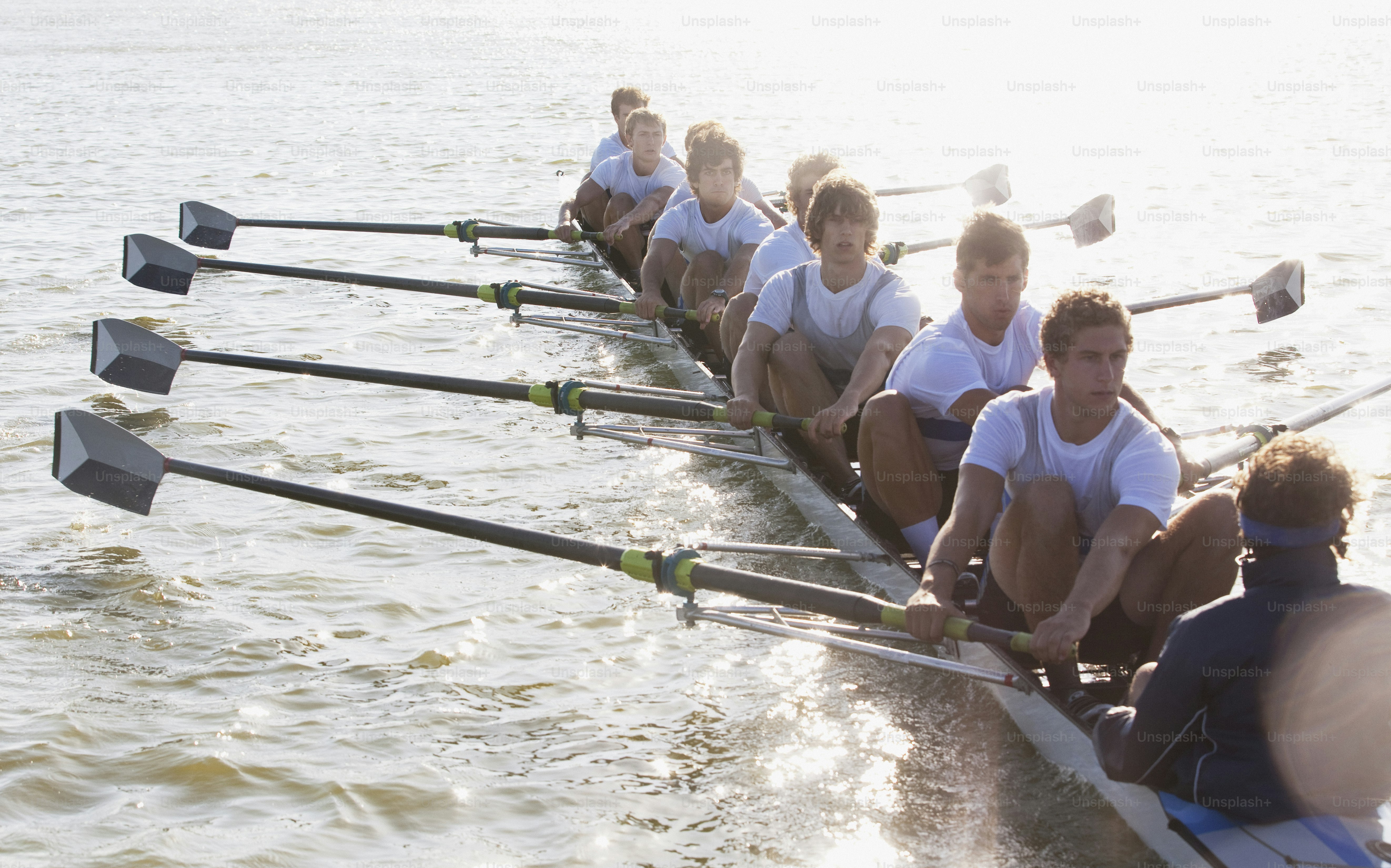 A group of people rowing a long boat in the water photo – Rowing Image ...