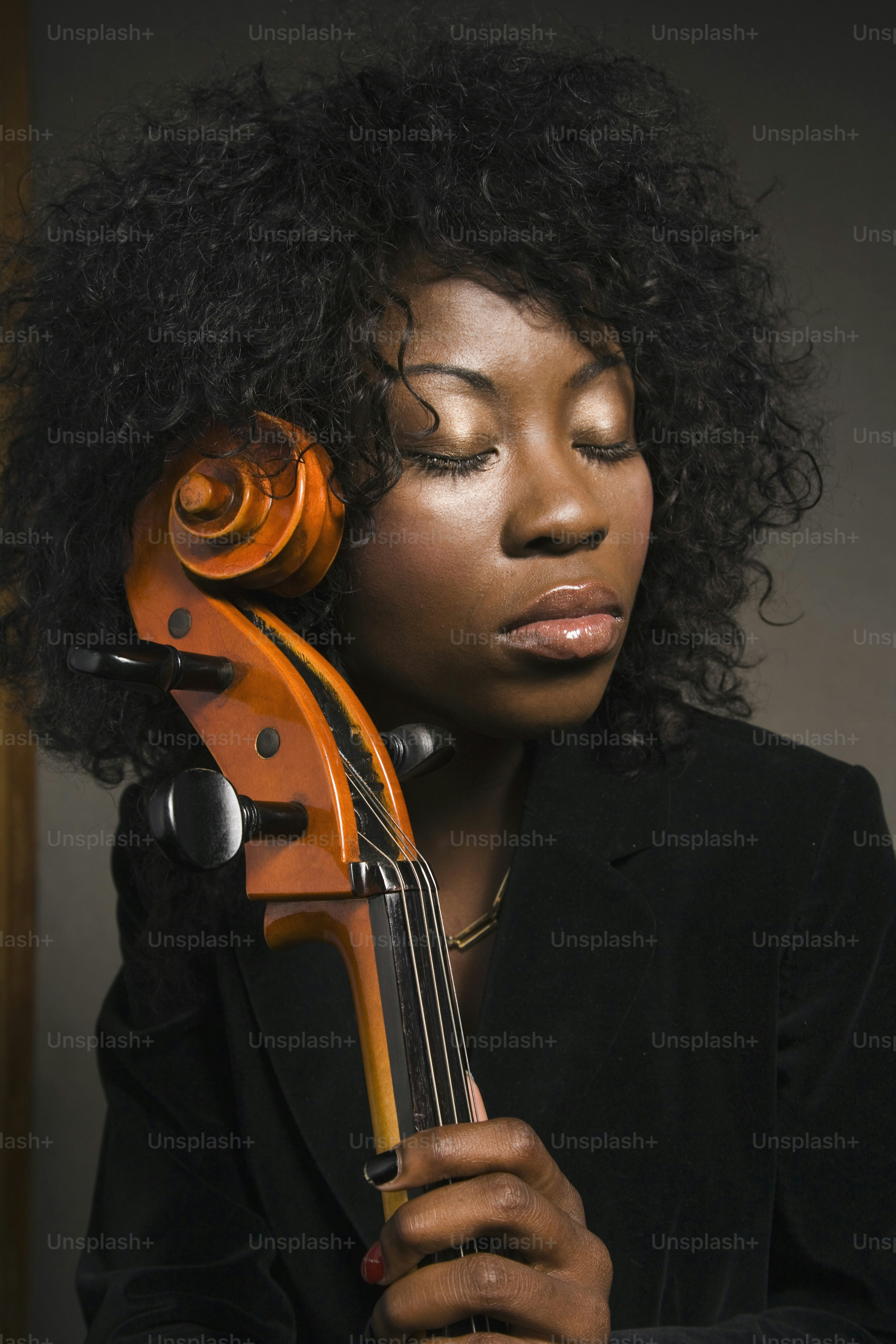 A woman with curly hair holding a violin photo – African-american lady ...
