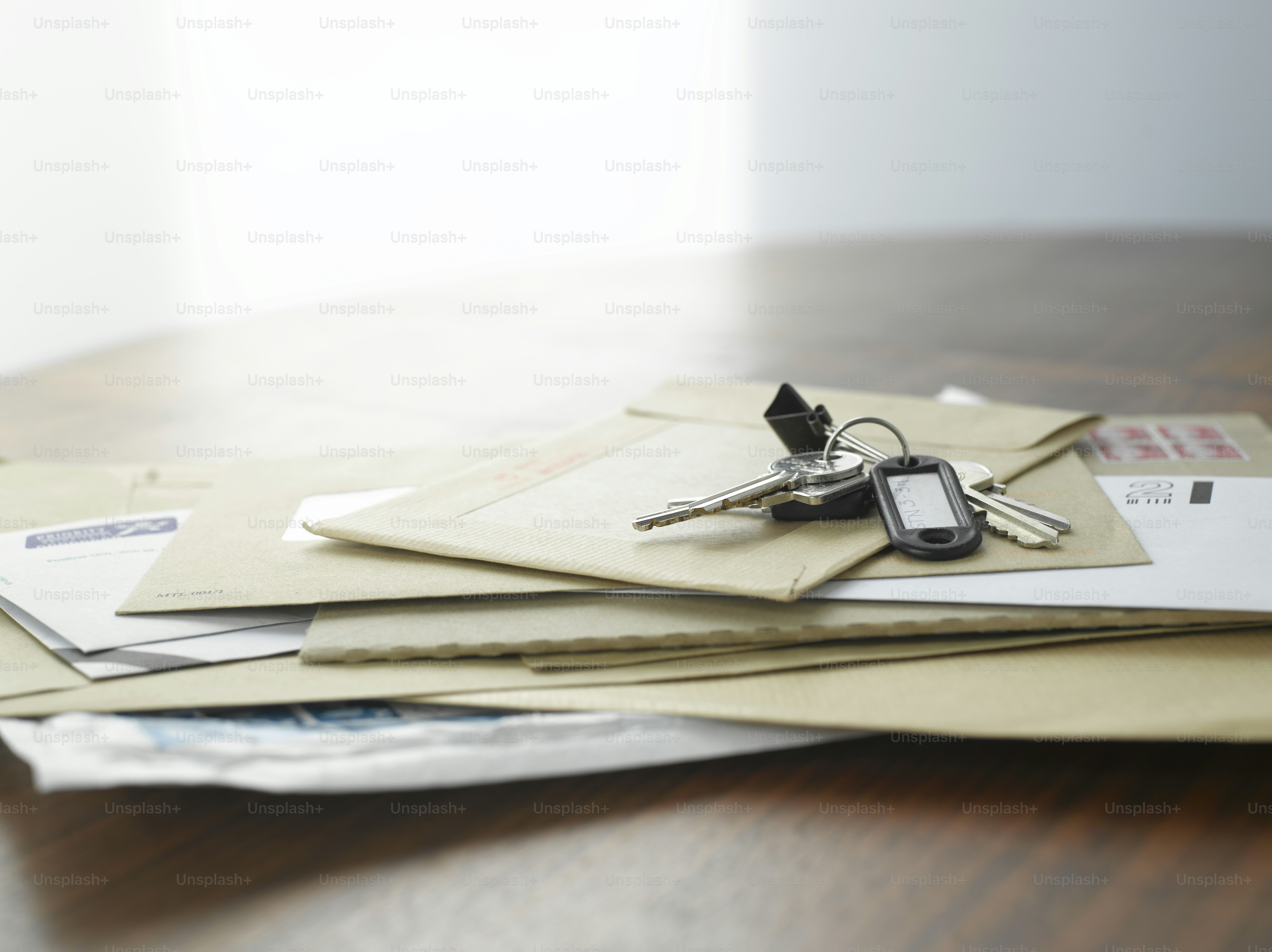 A pile of envelopes and keys on a table photo – House key Image on Unsplash
