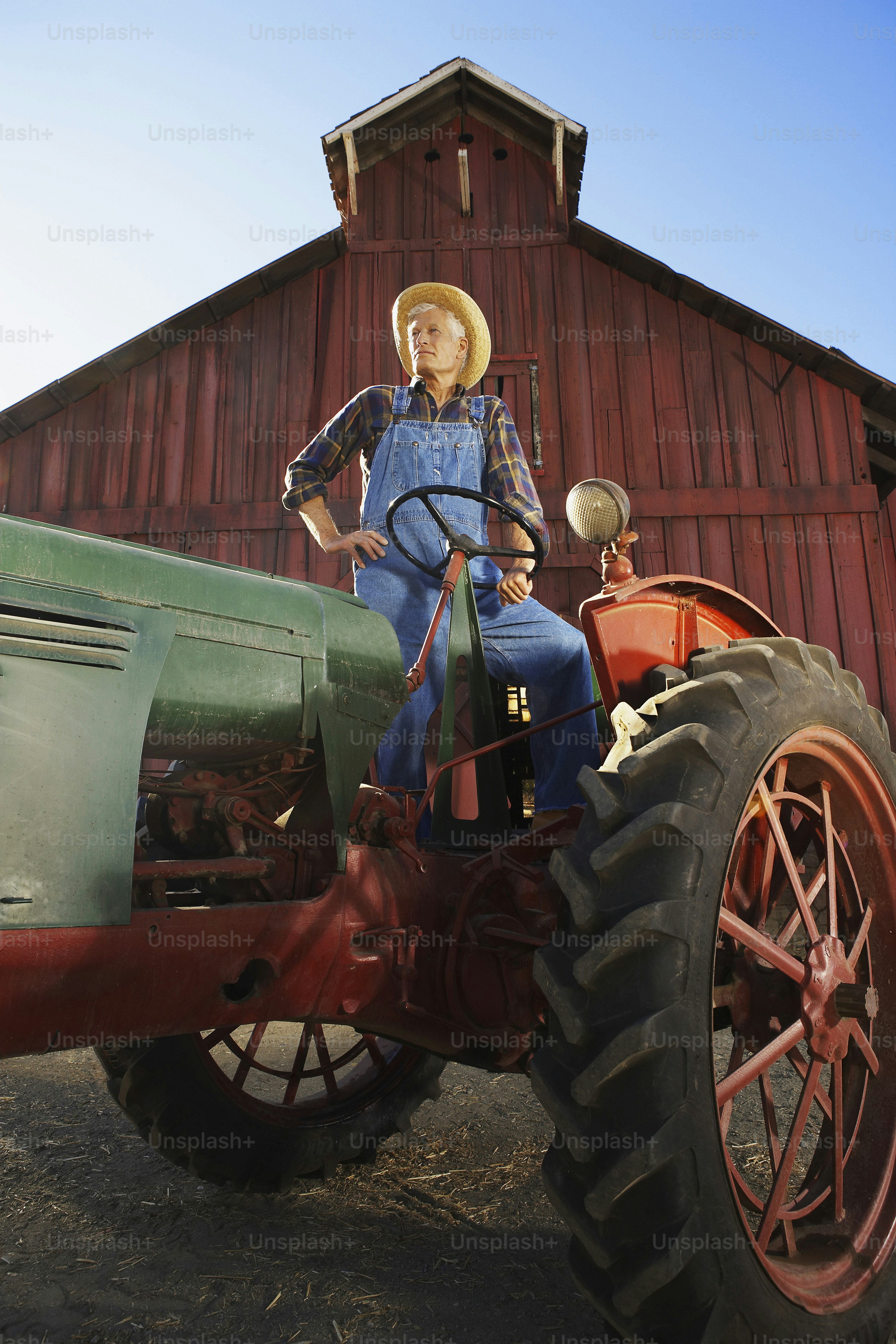 A woman standing on top of a tractor photo – Tractor Image on Unsplash