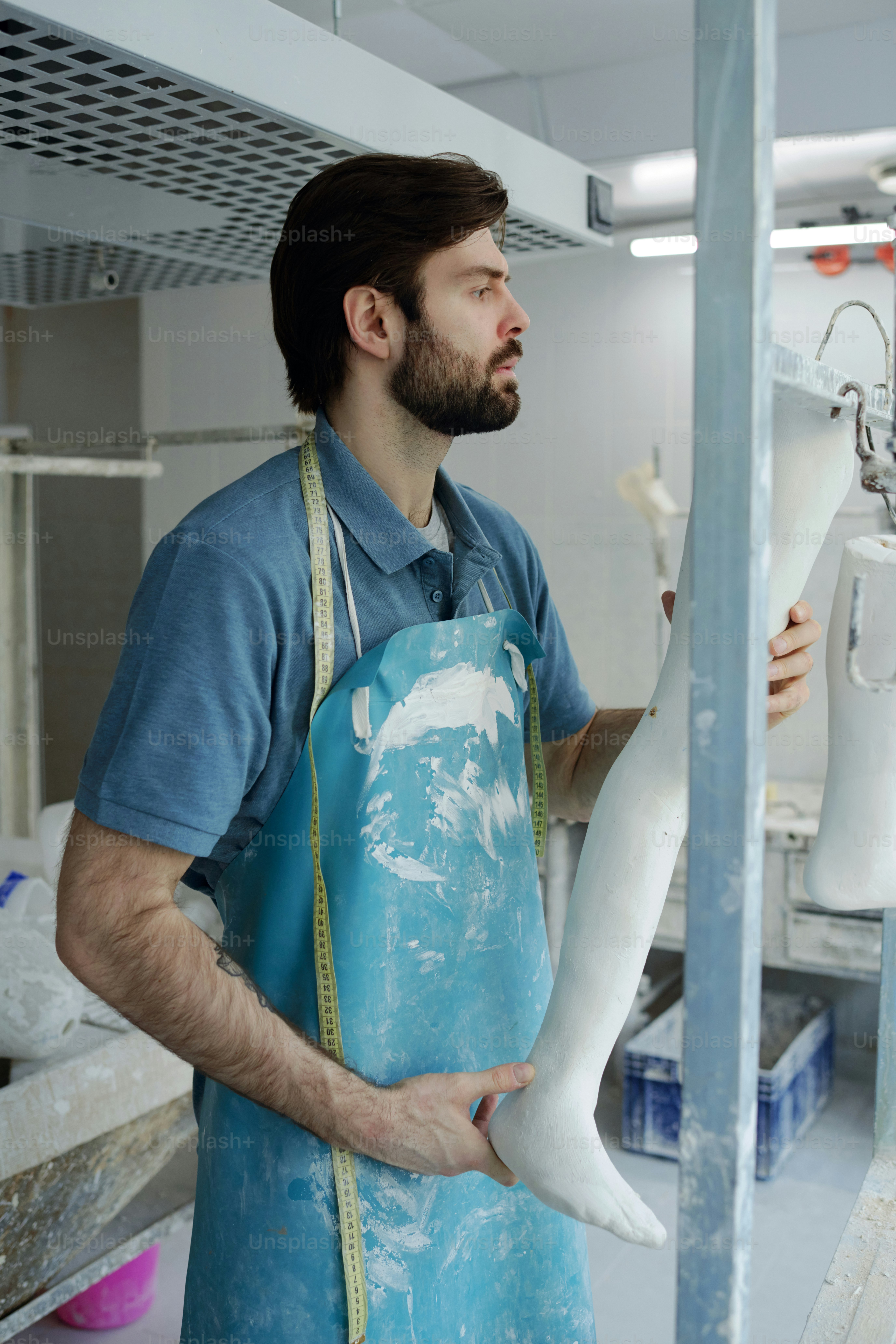 Serious young specialist of prosthetic factory holding plaster cast of ...