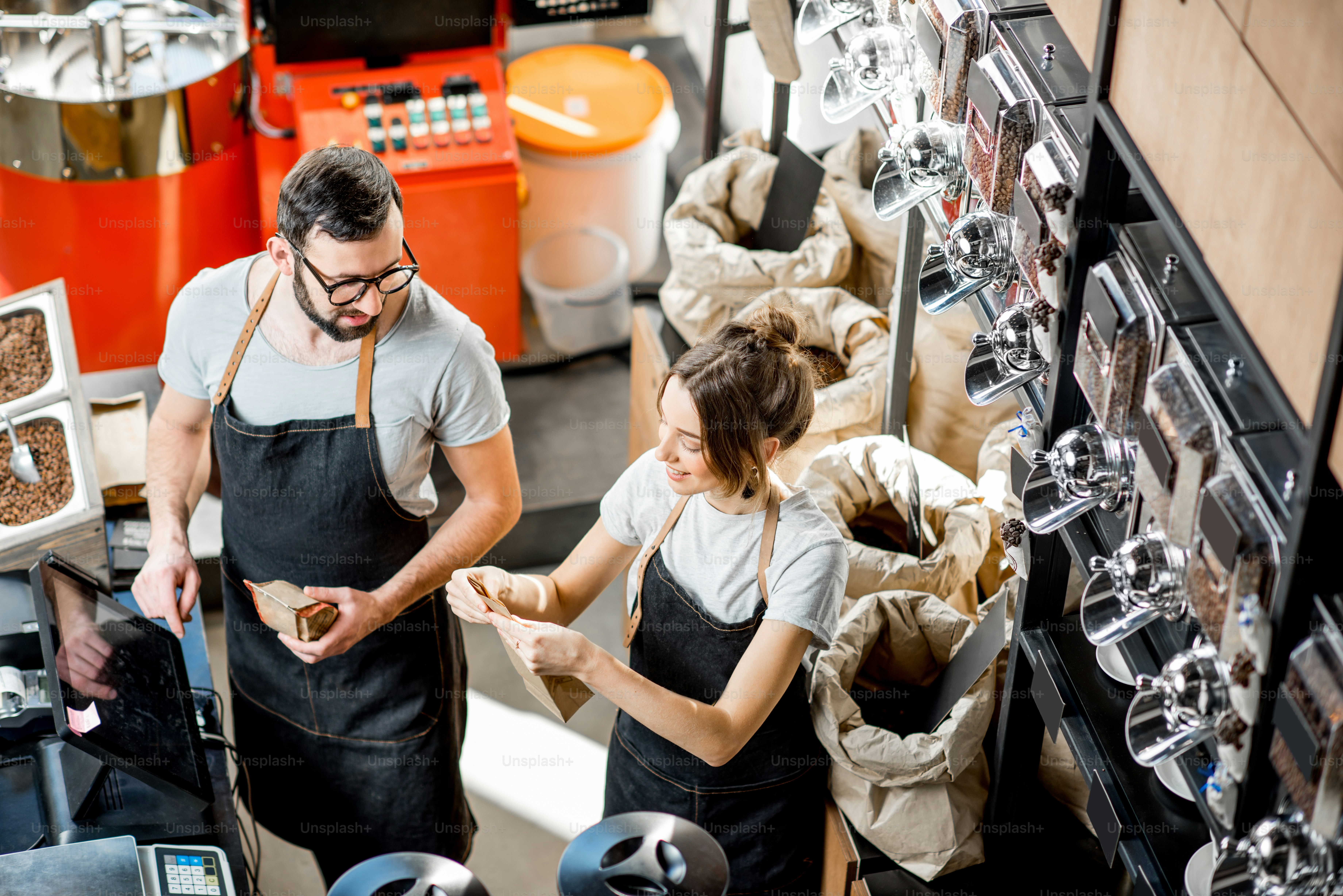 Foto Dos vendedores uniformados llenando y pesando bolsas con café en ...