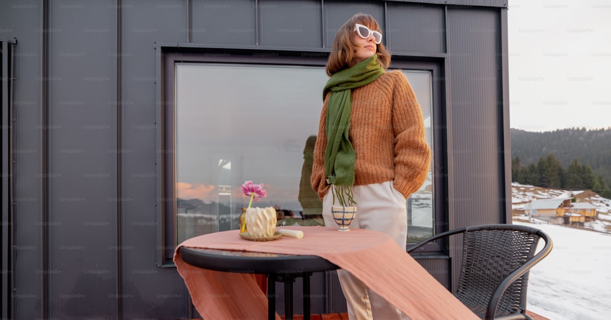 Foto Mujer joven con estilo de pie en la terraza de una pequeña casa en ... Foto Mujer joven con estilo de pie en la terraza de una pequeña casa en ...