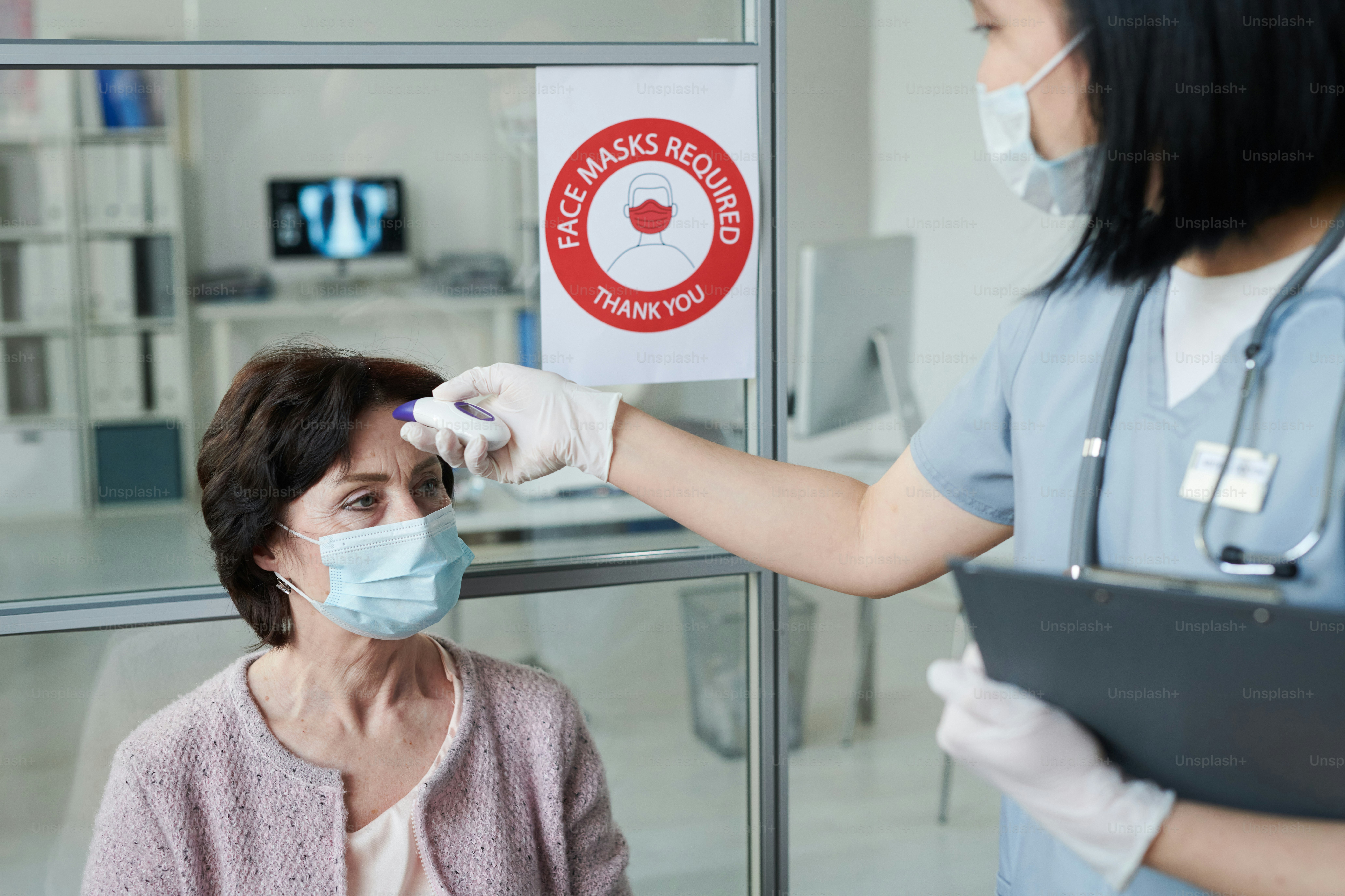 Foto Doctora o enfermera joven enguantada en uniforme que mide la ...