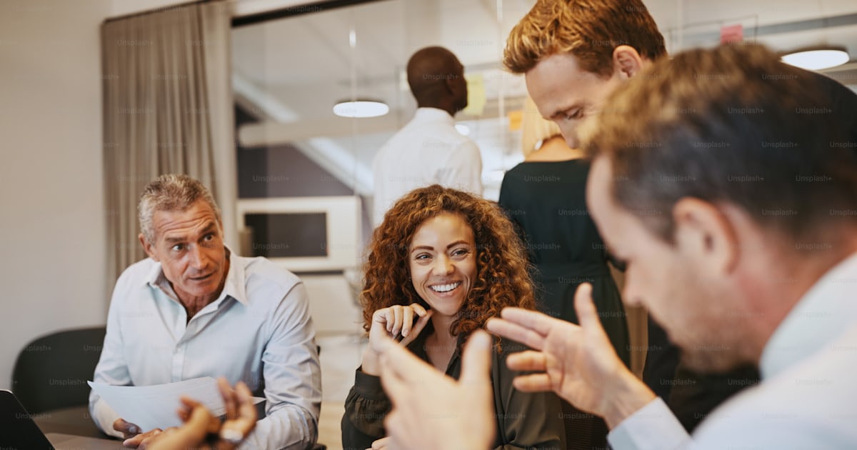 Diverse group of smiling businesspeople talking together during a ... Diverse group of smiling businesspeople talking together during a ...