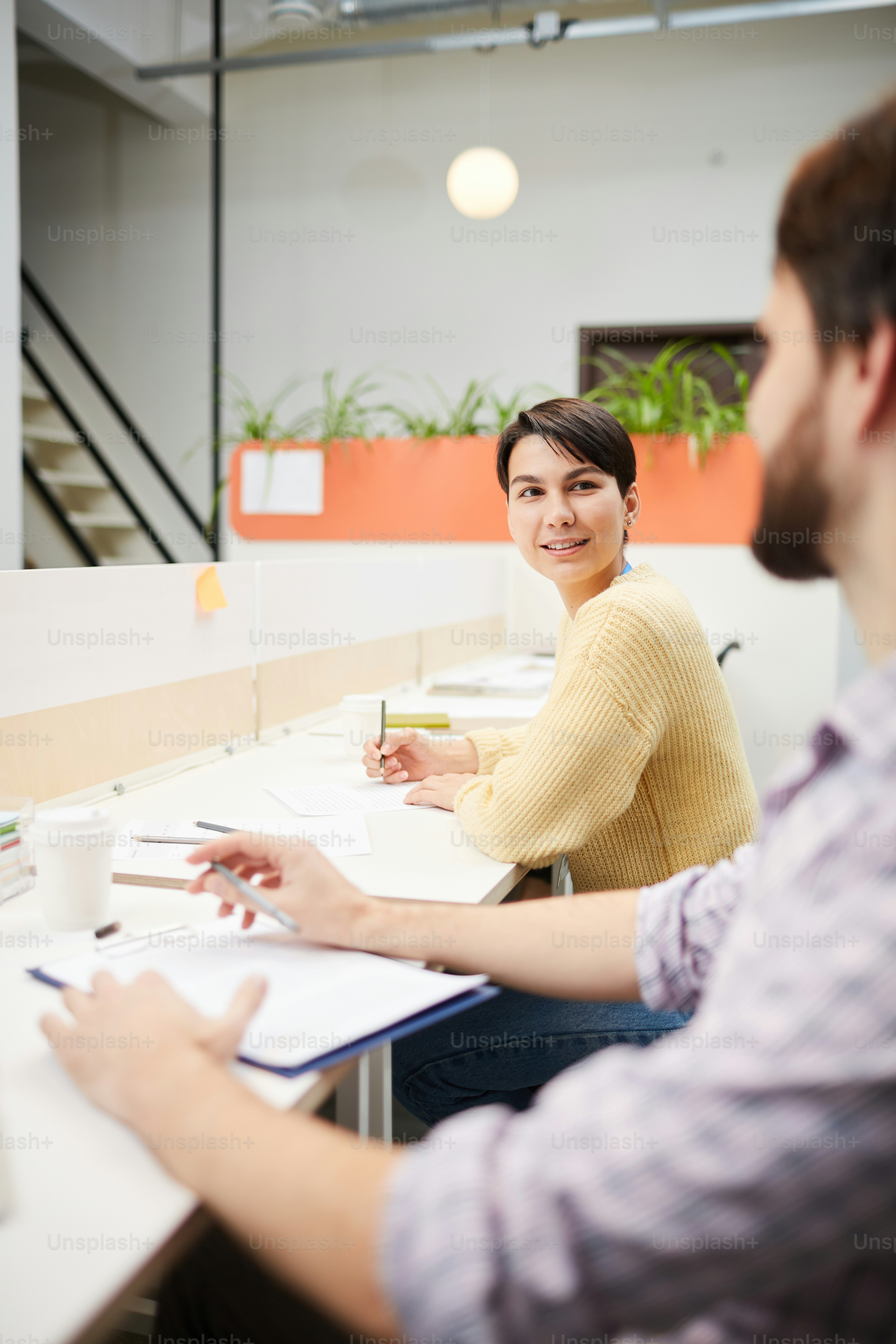 Foto zum Thema Glückliche junge brünette Buchhalterin schaut ihren ...