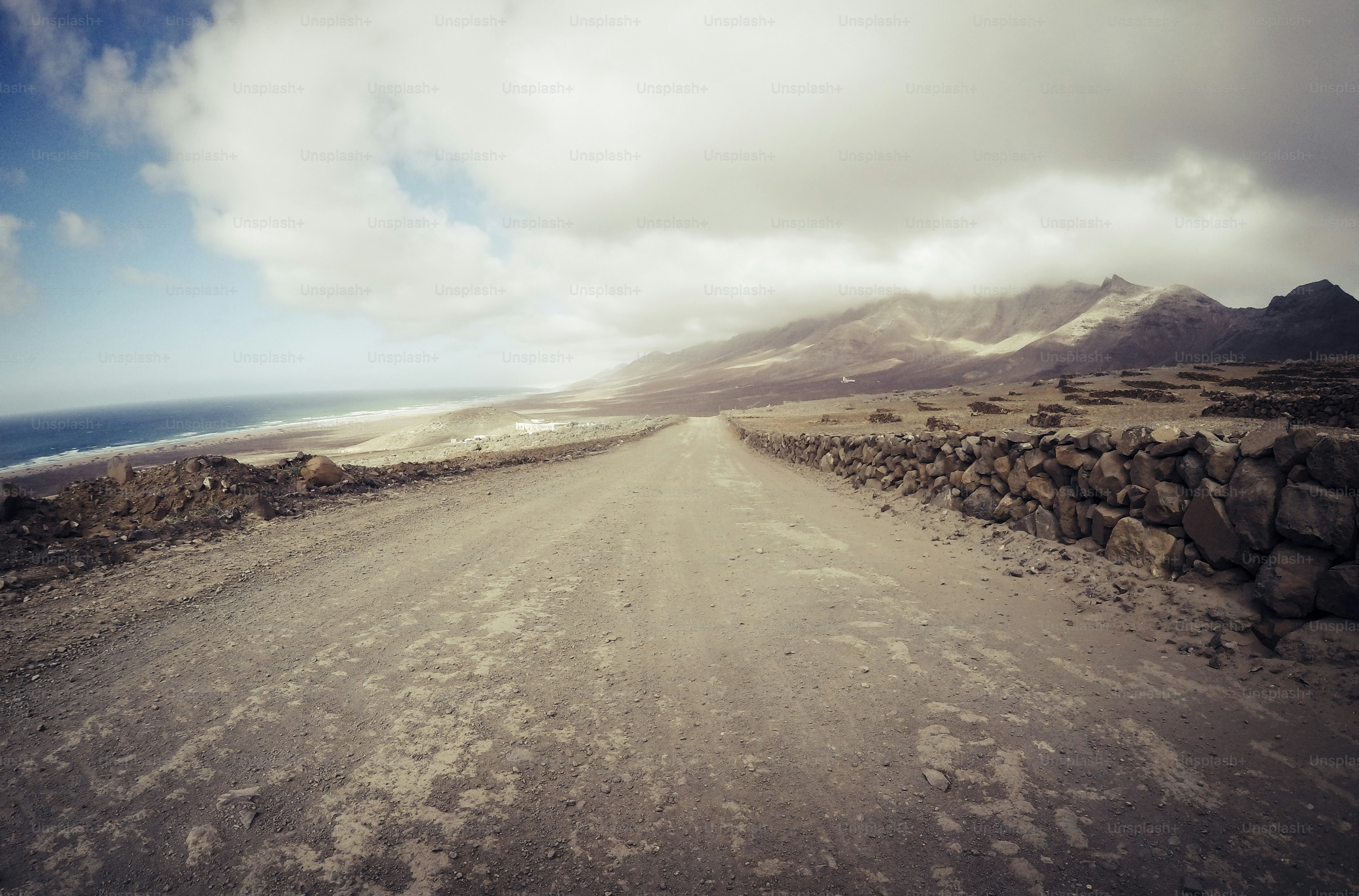 Long off road terrain way road viewed from ground level with mountains ...