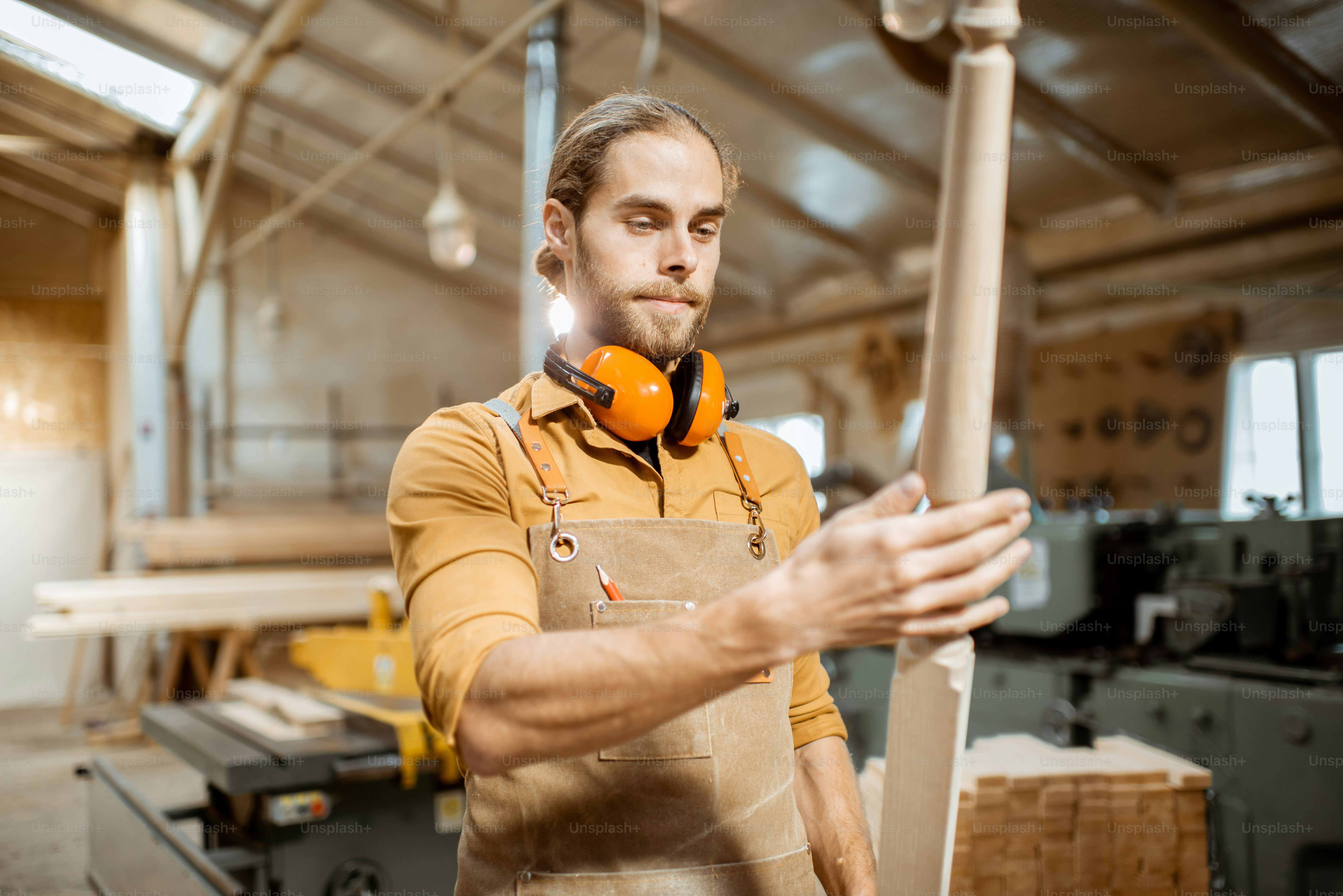 Foto Guapo carpintero en uniforme trabajando con madera, comprobando la ...