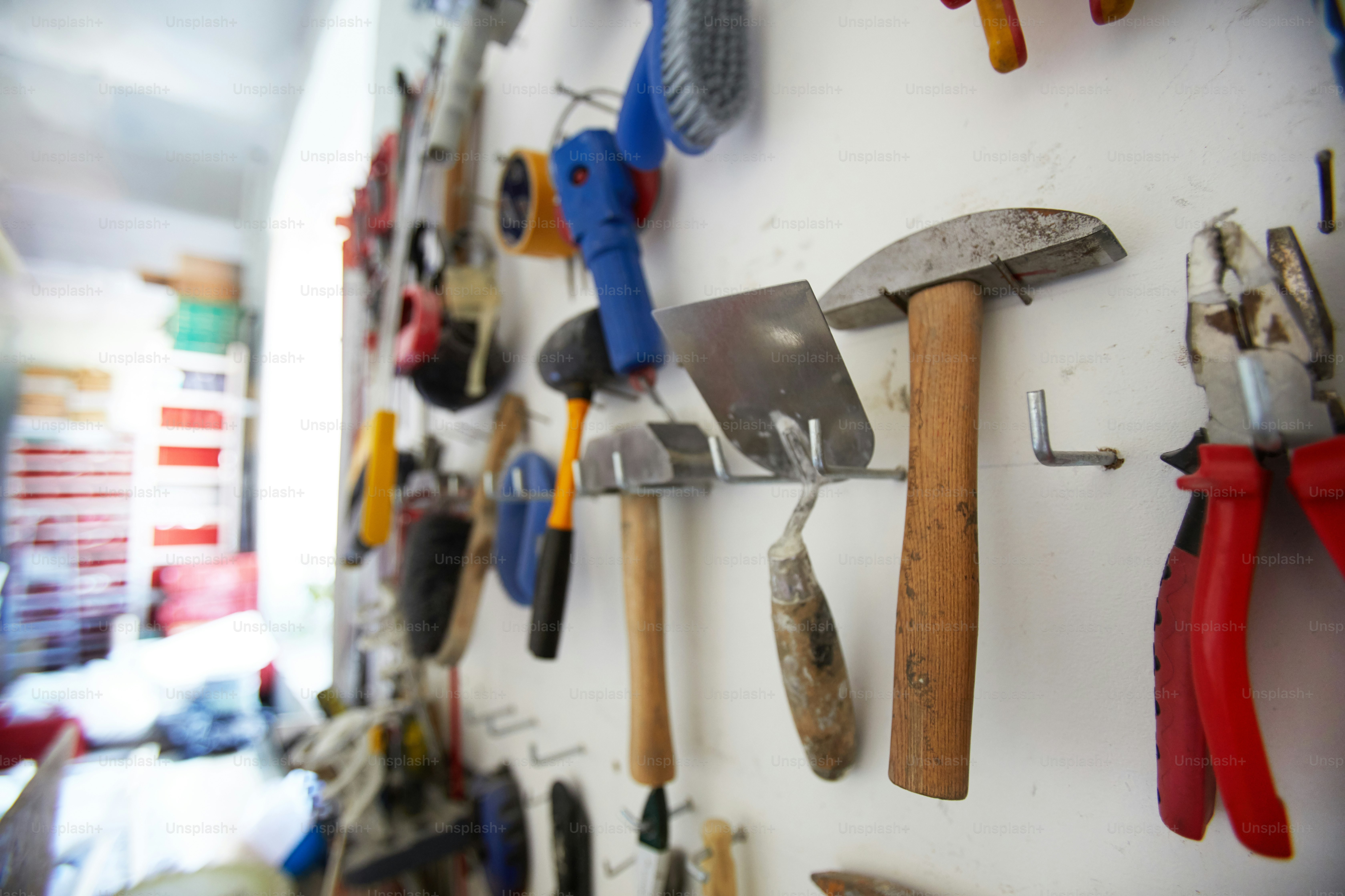 Set of handtools of artisan hanging along wall in modern workshop photo ...