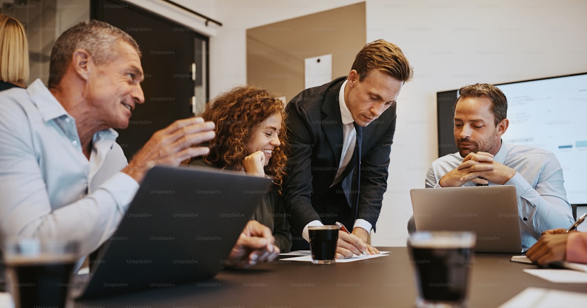 Group of smiling businesspeople talking together during a meeting ... Group of smiling businesspeople talking together during a meeting ...