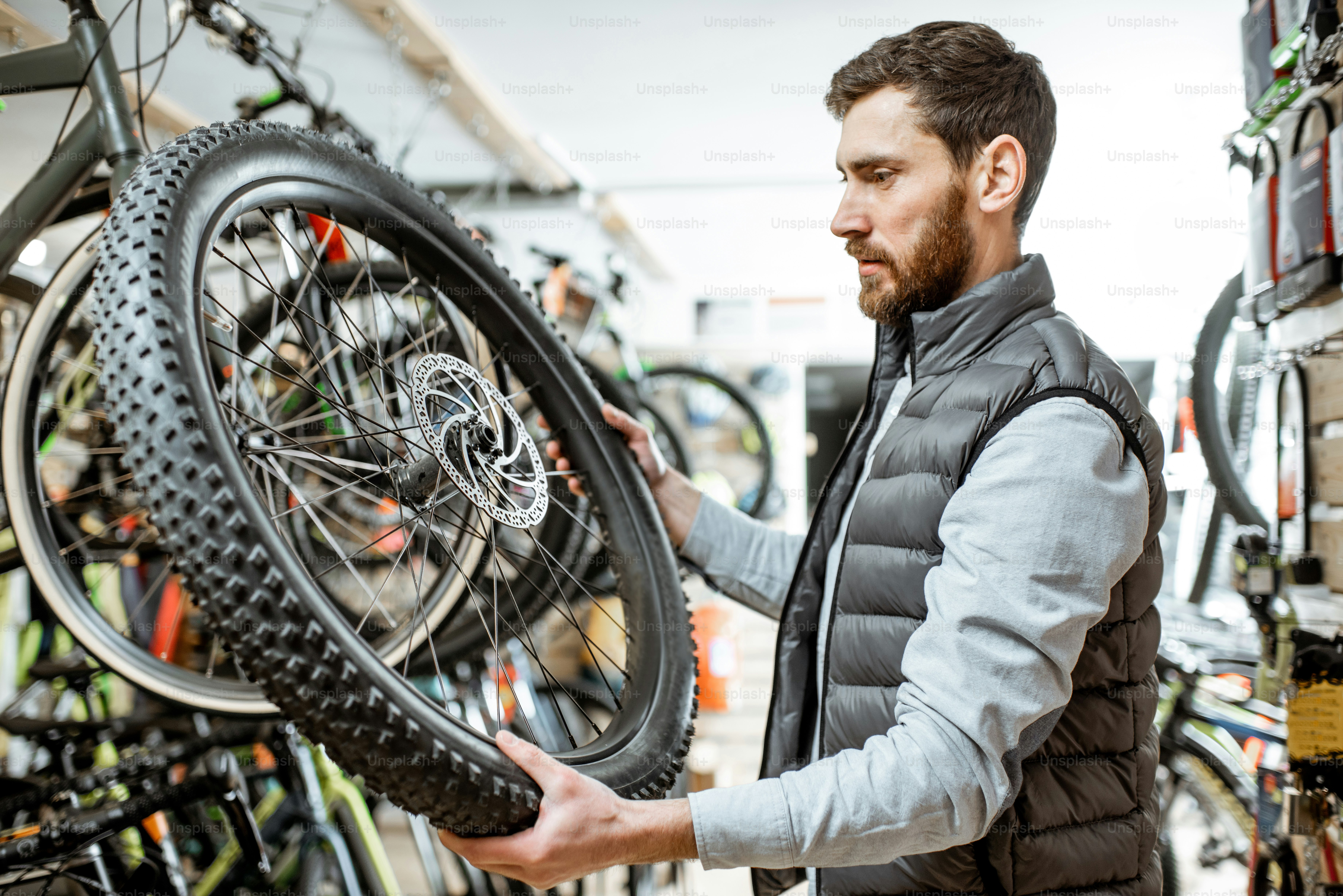 Portrait of a handsome man as a buyer or salesperson with bicycle wheel ...
