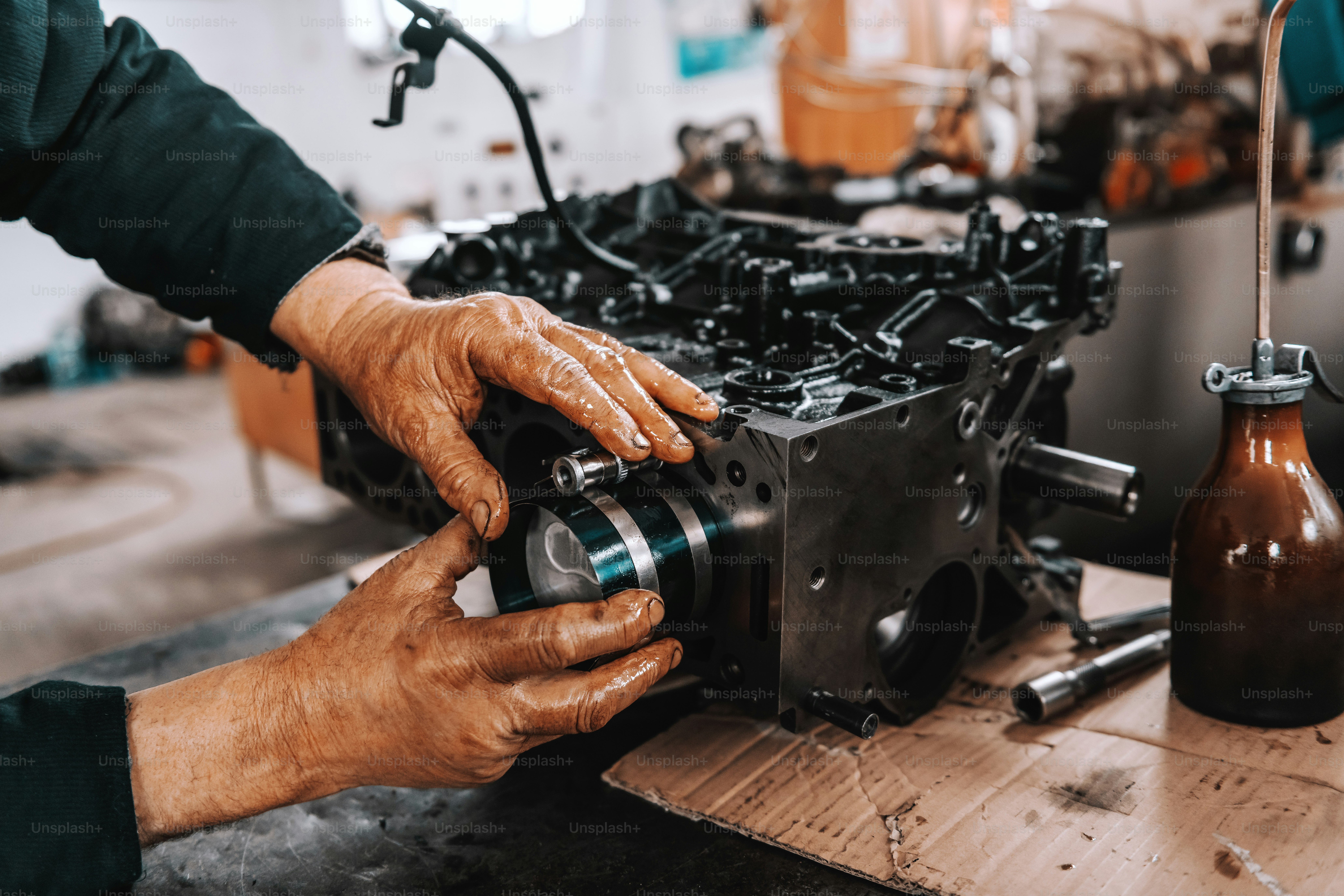 Auto mechanic adjusting cylinder on engine block at workshop. photo ...