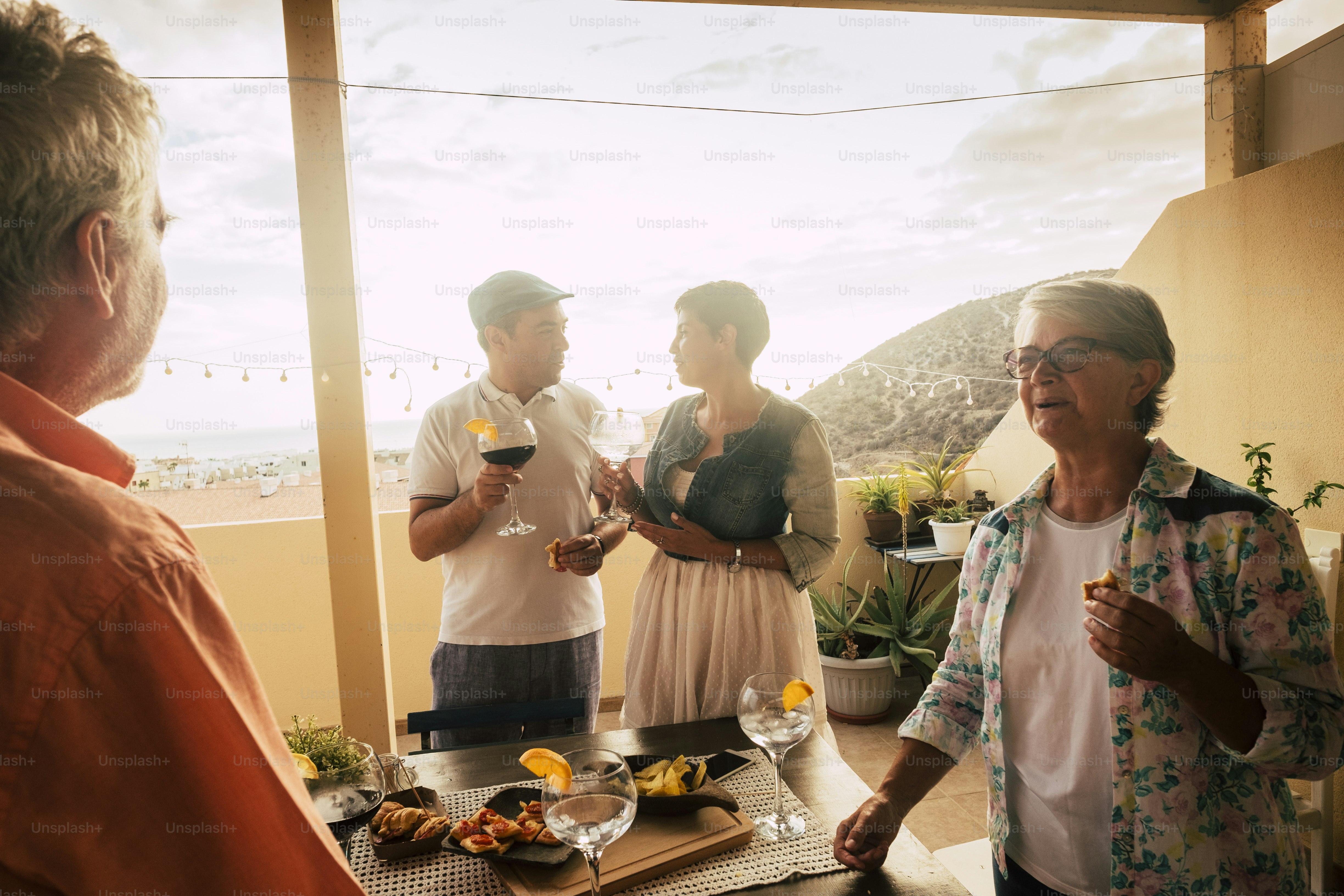 Group of mixed ages people enjoy food and drinks together in friendship ...
