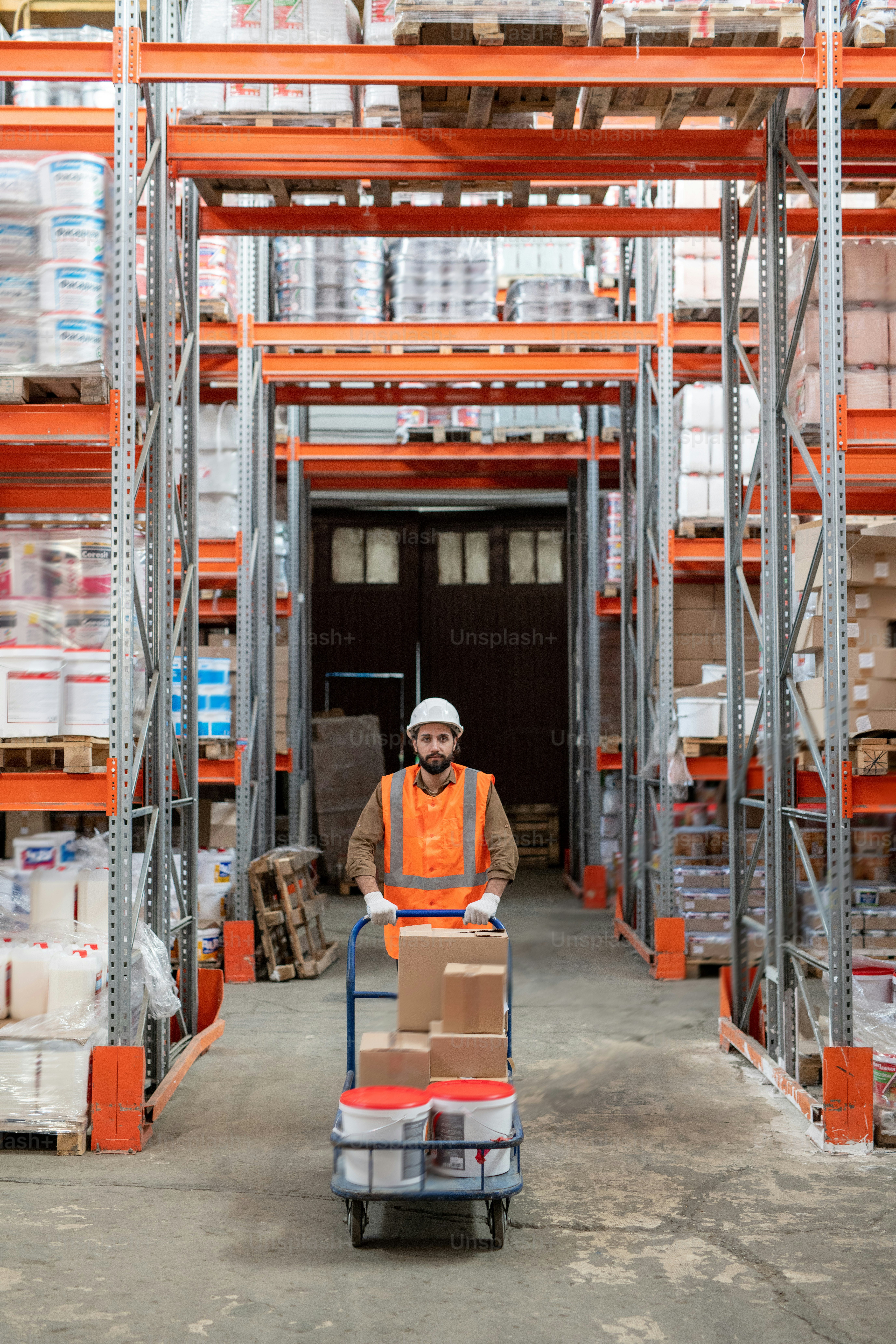 Warehouse engineer in workwear moving forwards between racks photo – Adult Image on Unsplash