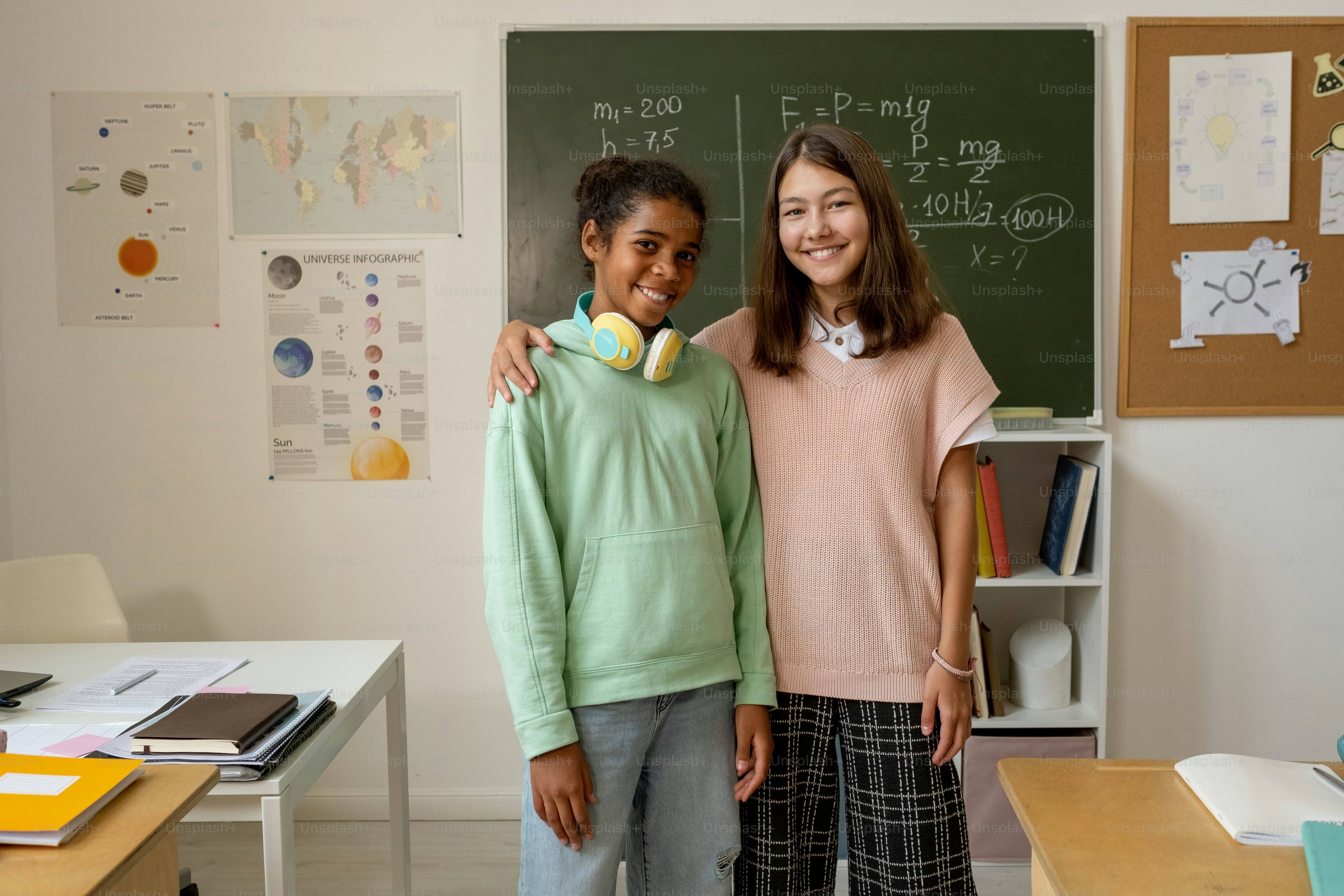 Two cheerful multiracial schoolgirls in casualwear standing against ...