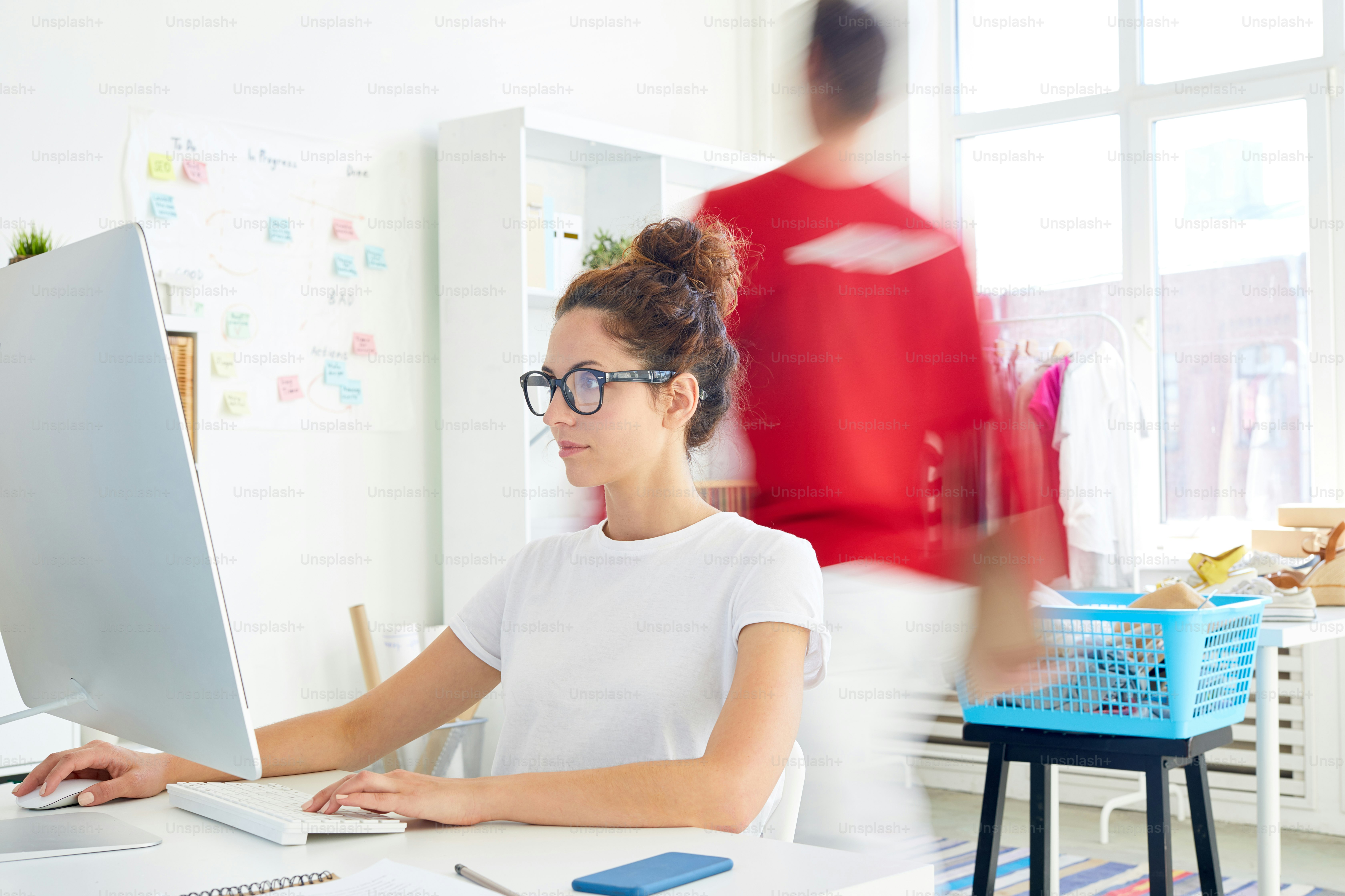 Young fashion designer or stylist sitting in front of computer and ...