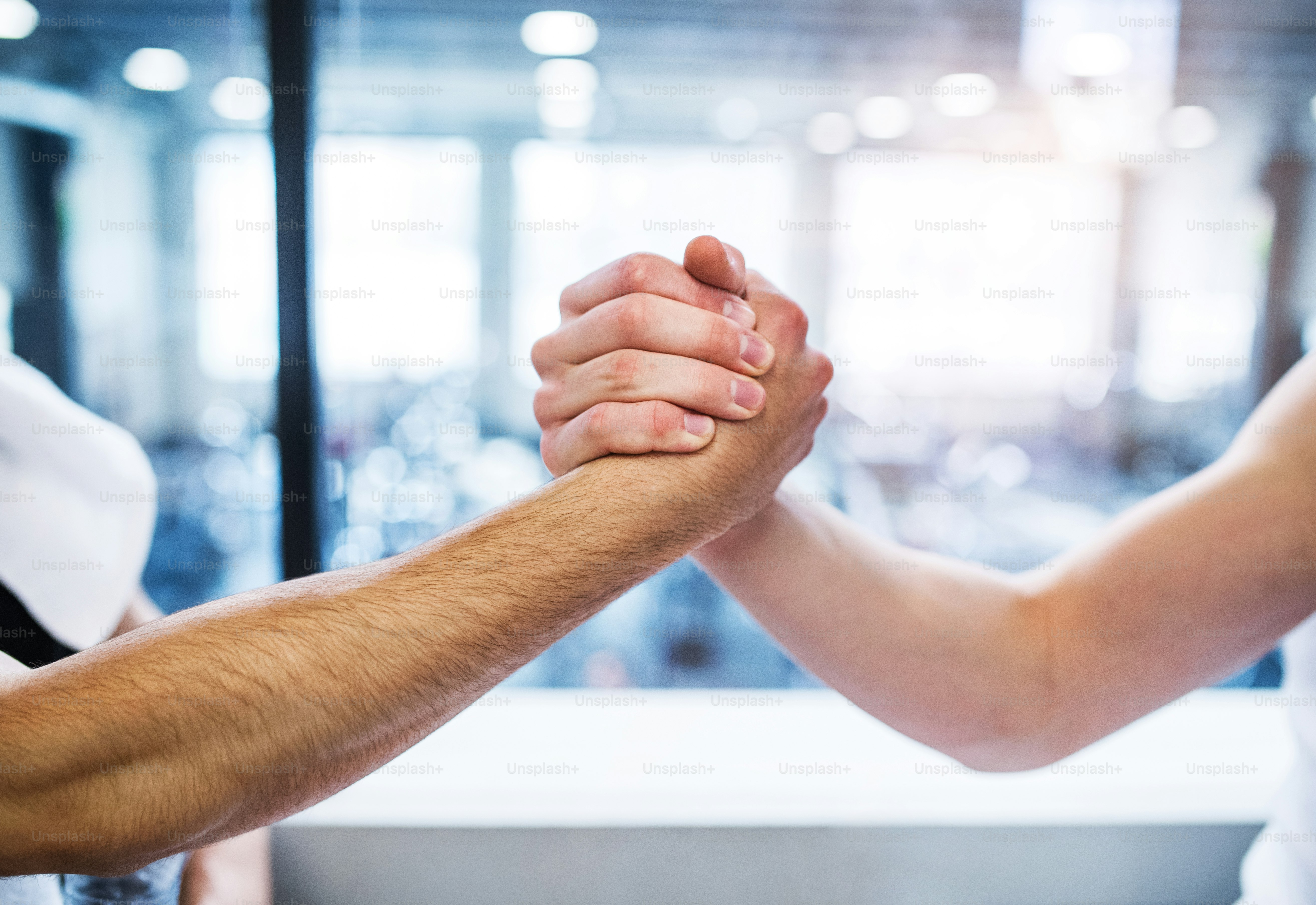 A friendly handshake of two young unrecognizable men in gym gym. A ...