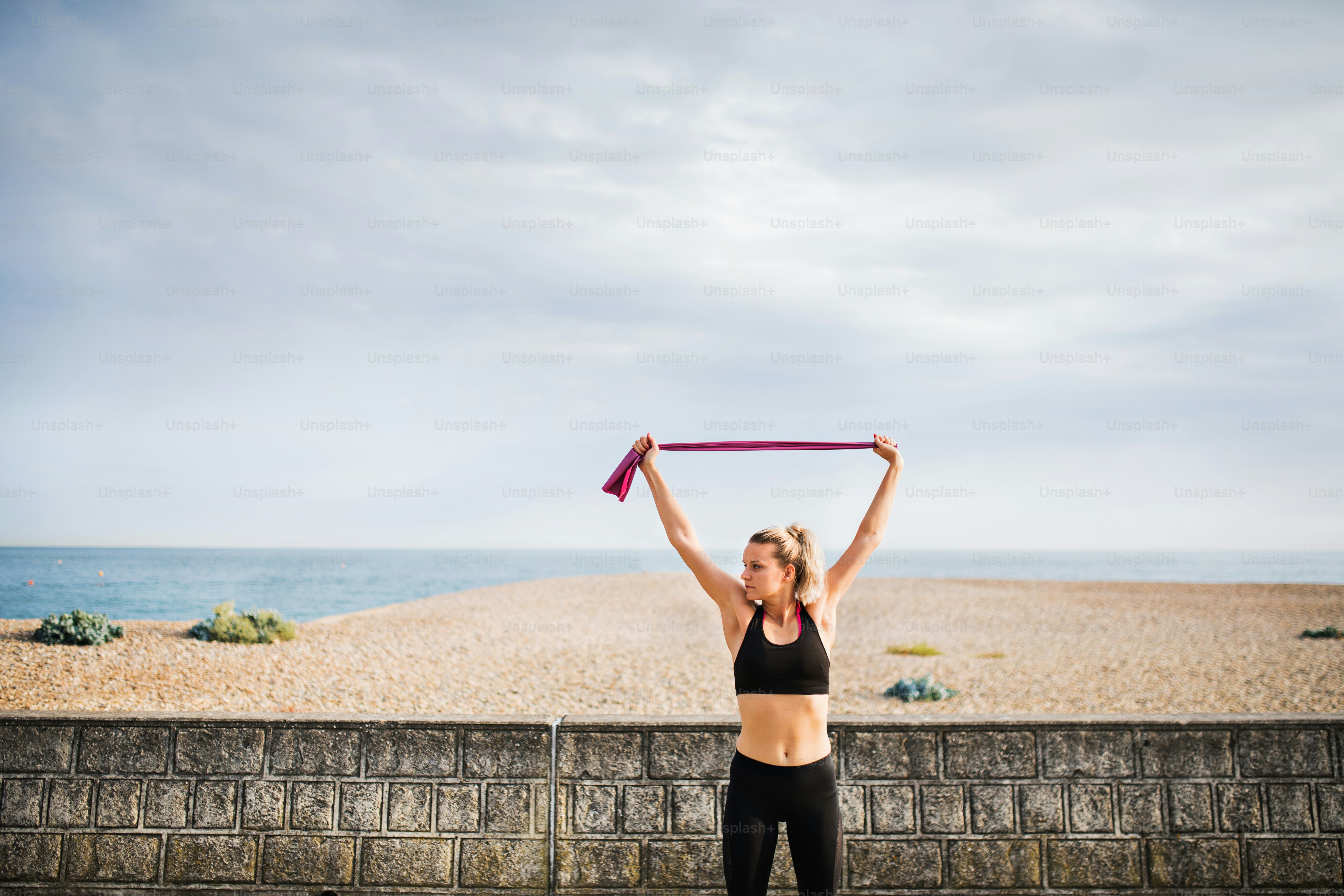 Young sporty woman runner doing exercise with elastic rubber bands ...