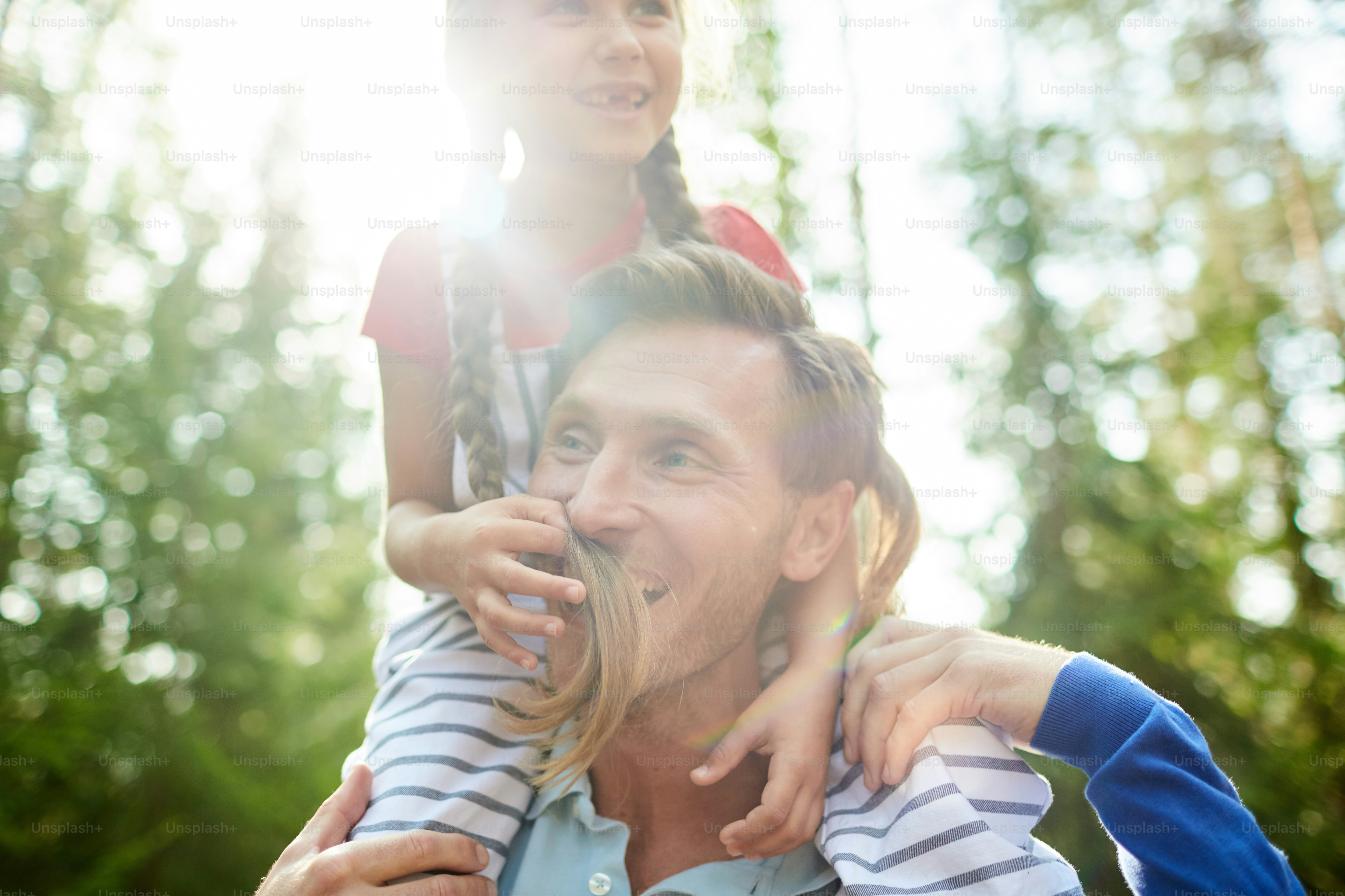 Little daughter having fun with dad during chill in the forest on sunny ...