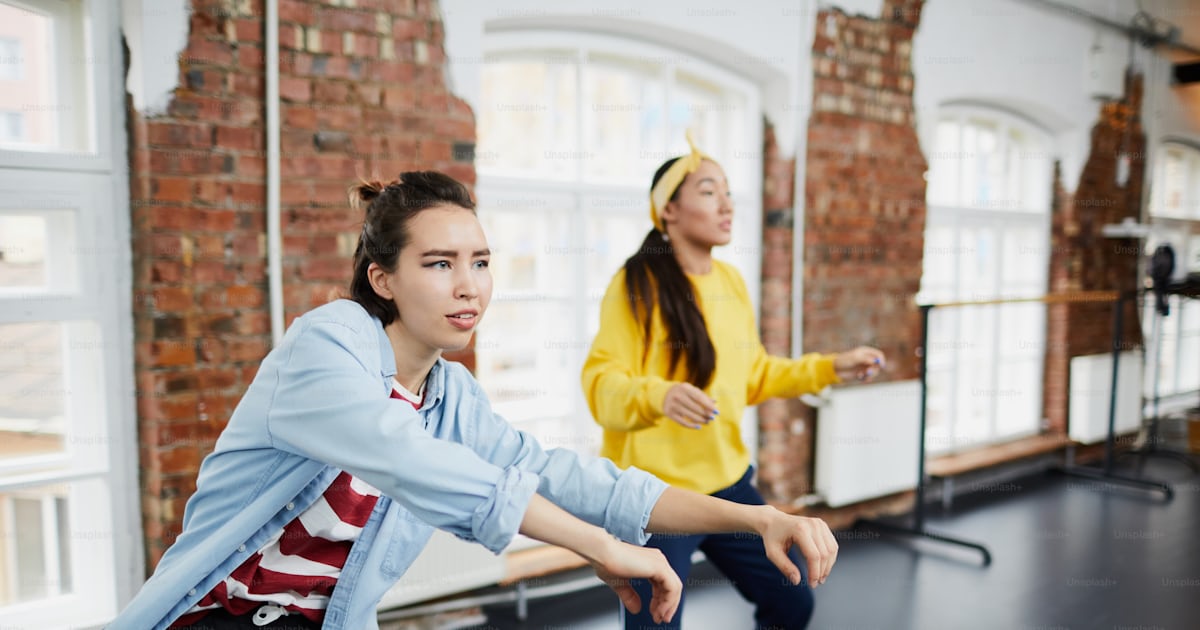 현대 스튜디오에서 힙합 춤을 배우는 젊은 활동적인 여성과 그녀의 그룹 동료 사진 Unsplash의 사진술 이미지