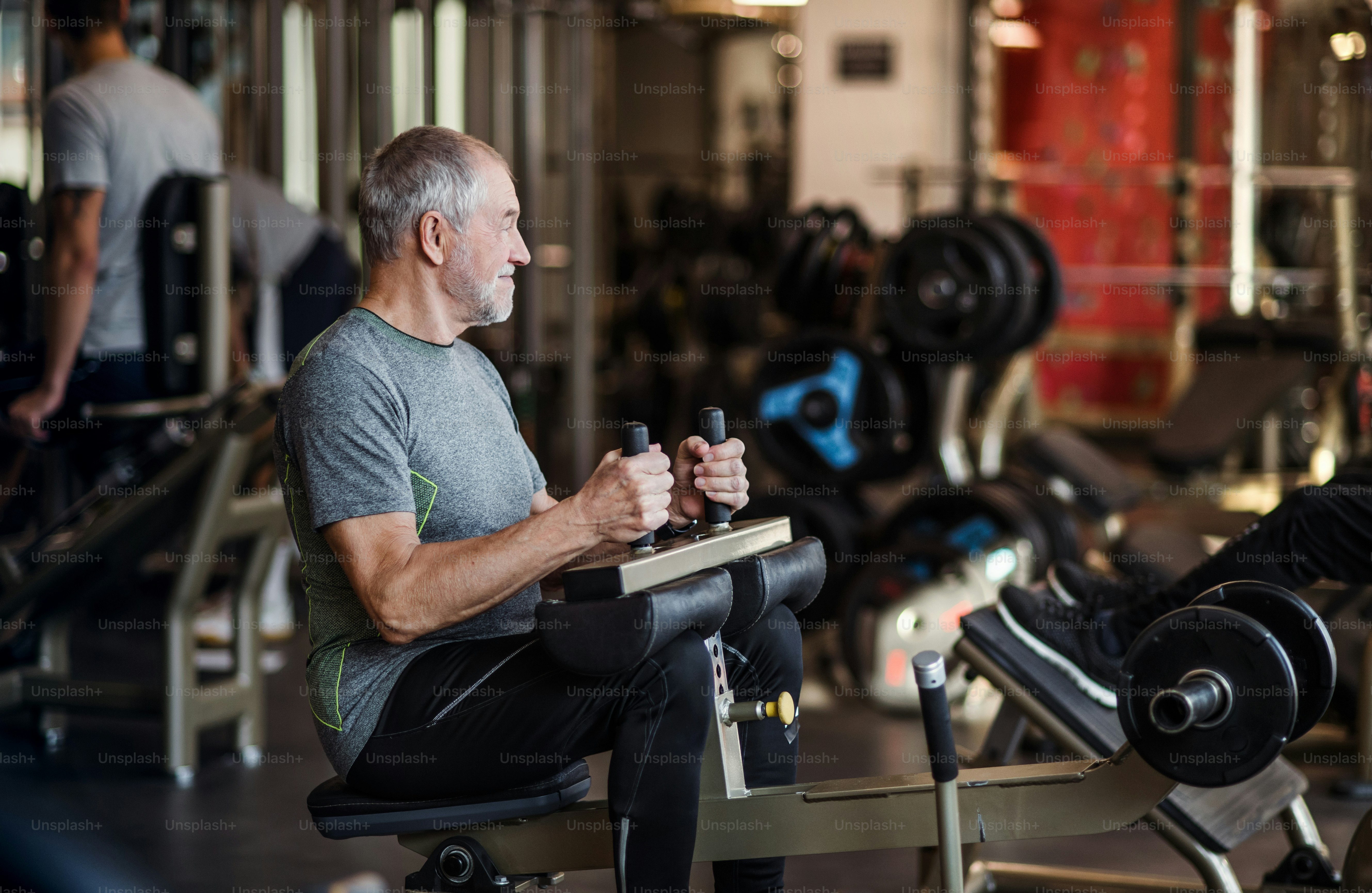 A senior man doing strength workout exercise in gym. A copy space ...