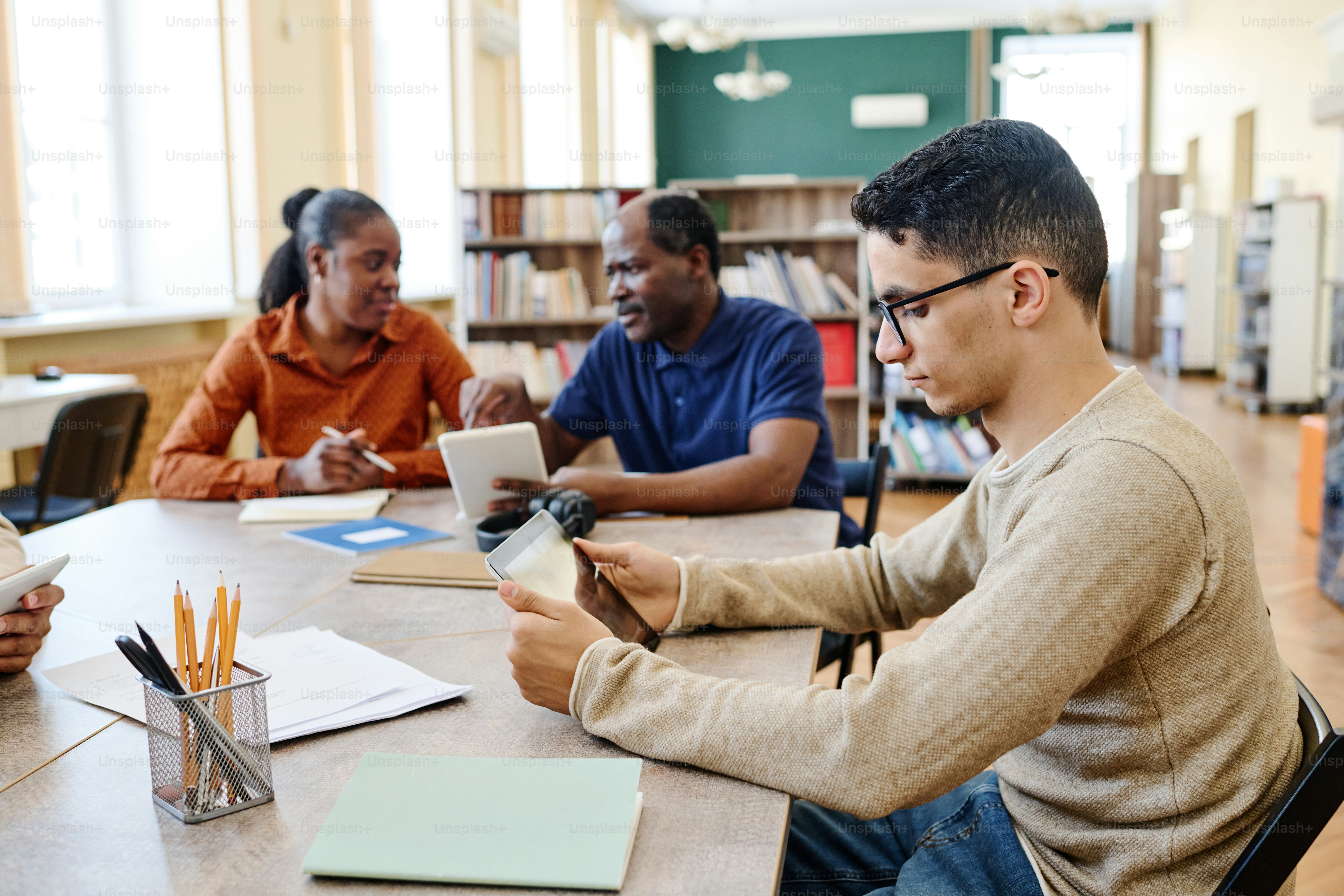 Young Middle Eastern student and his Black classmates attending lesson ...