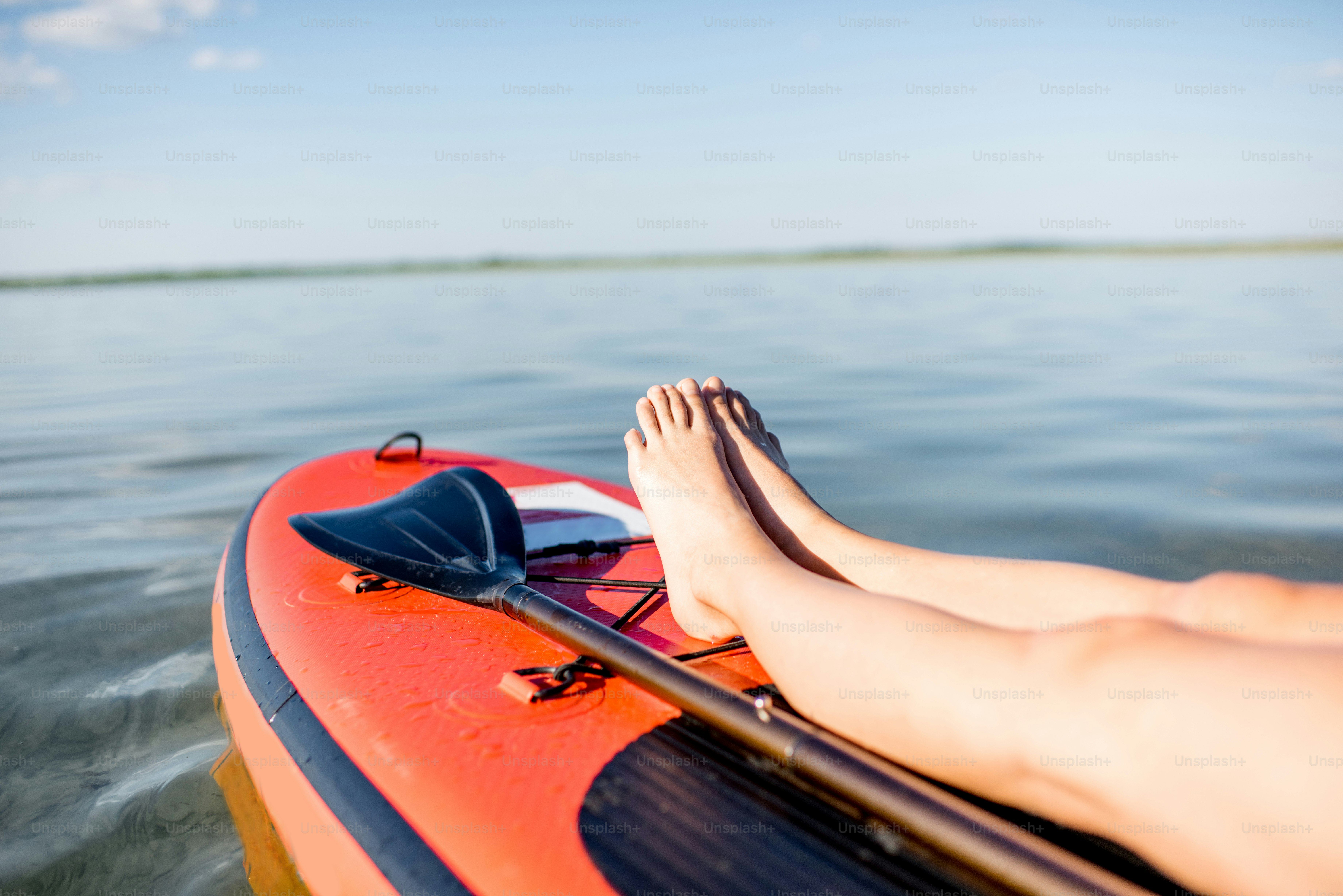 Young woman relaxing on the paddleboard on the lake. Close-up view ...