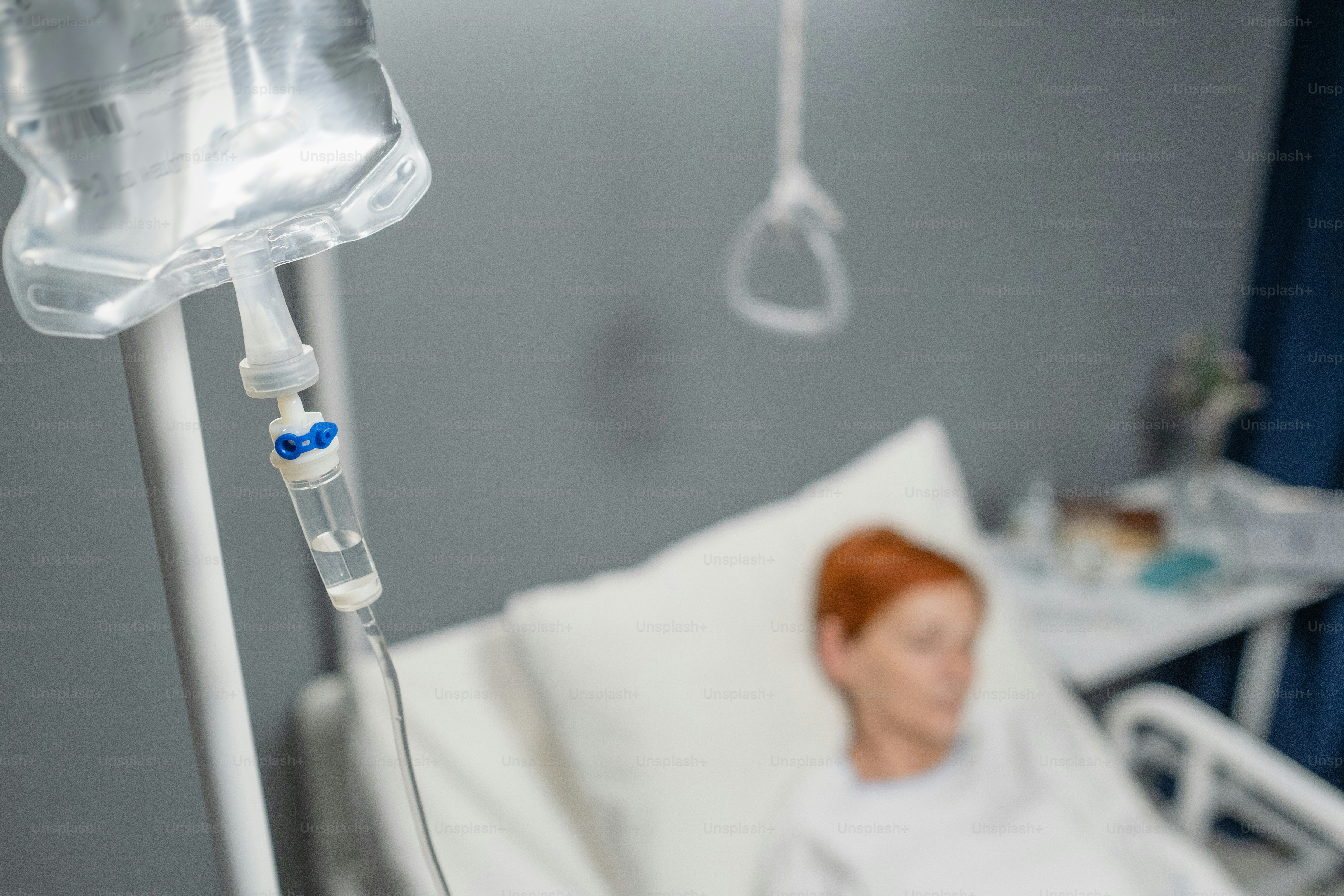 Gros plan d’une perfusion intraveineuse suspendue au-dessus du lit avec ...
