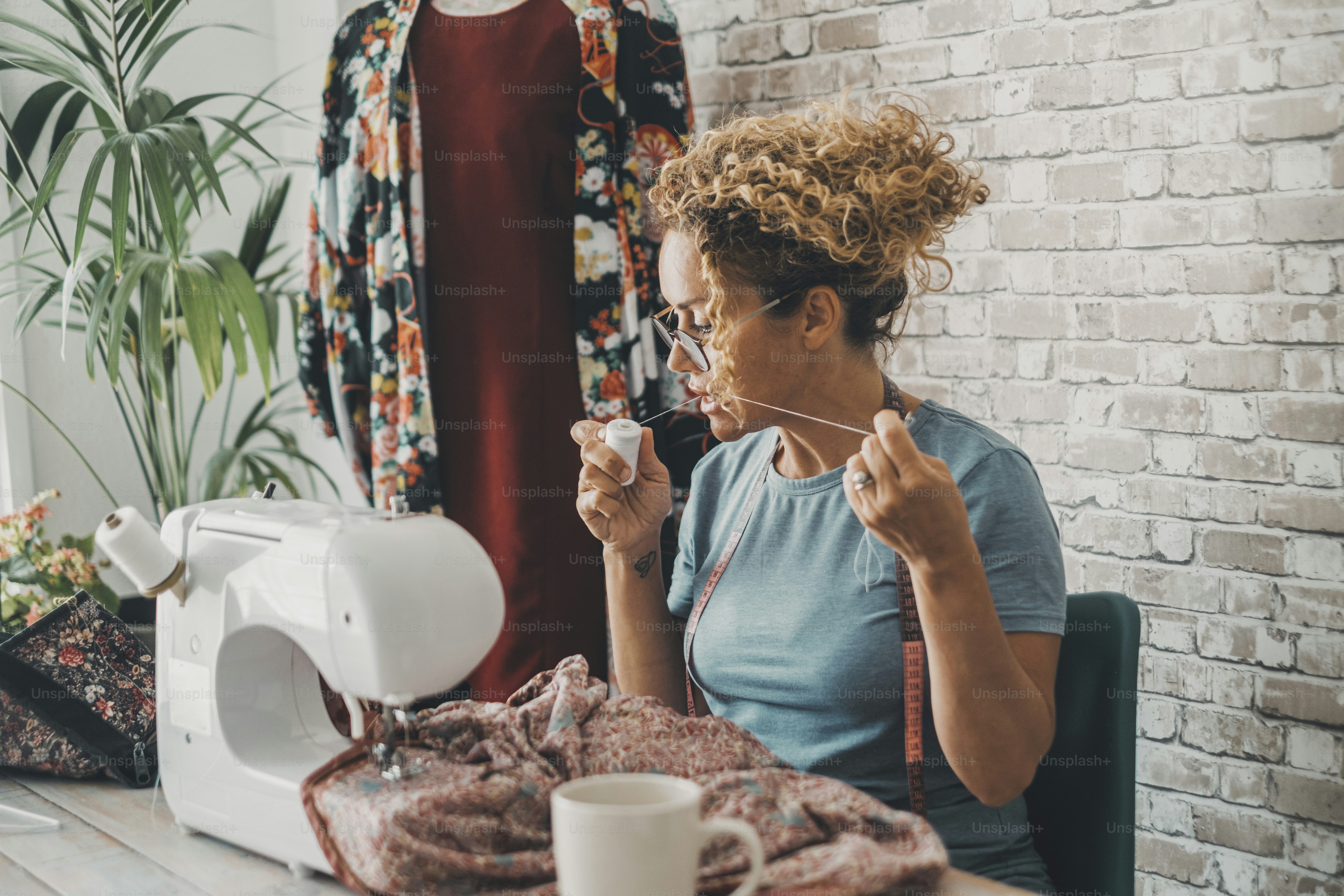 Woman at home use sewing machine for tailoring business activity ...