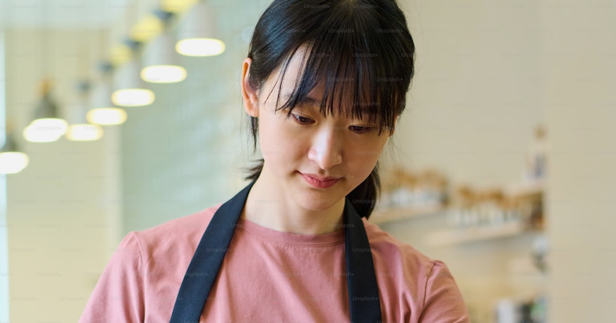 카페 개장 전에 앞치마를 입고 테이블을 닦는 젊은 아시아 웨이트리스 사진 Unsplash의 러시아 이미지