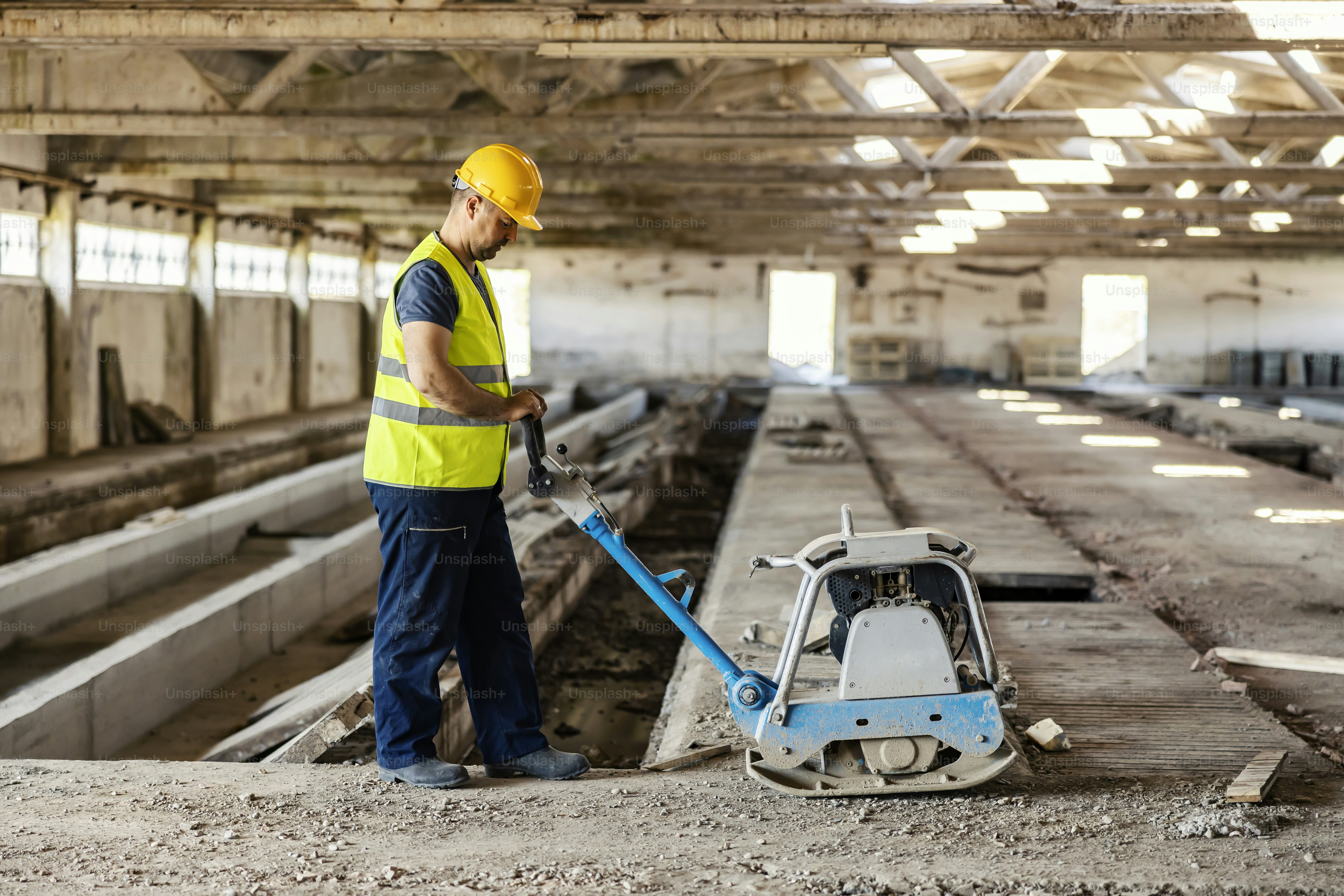 A worker manipulate with trampling machine at construction site. photo ...