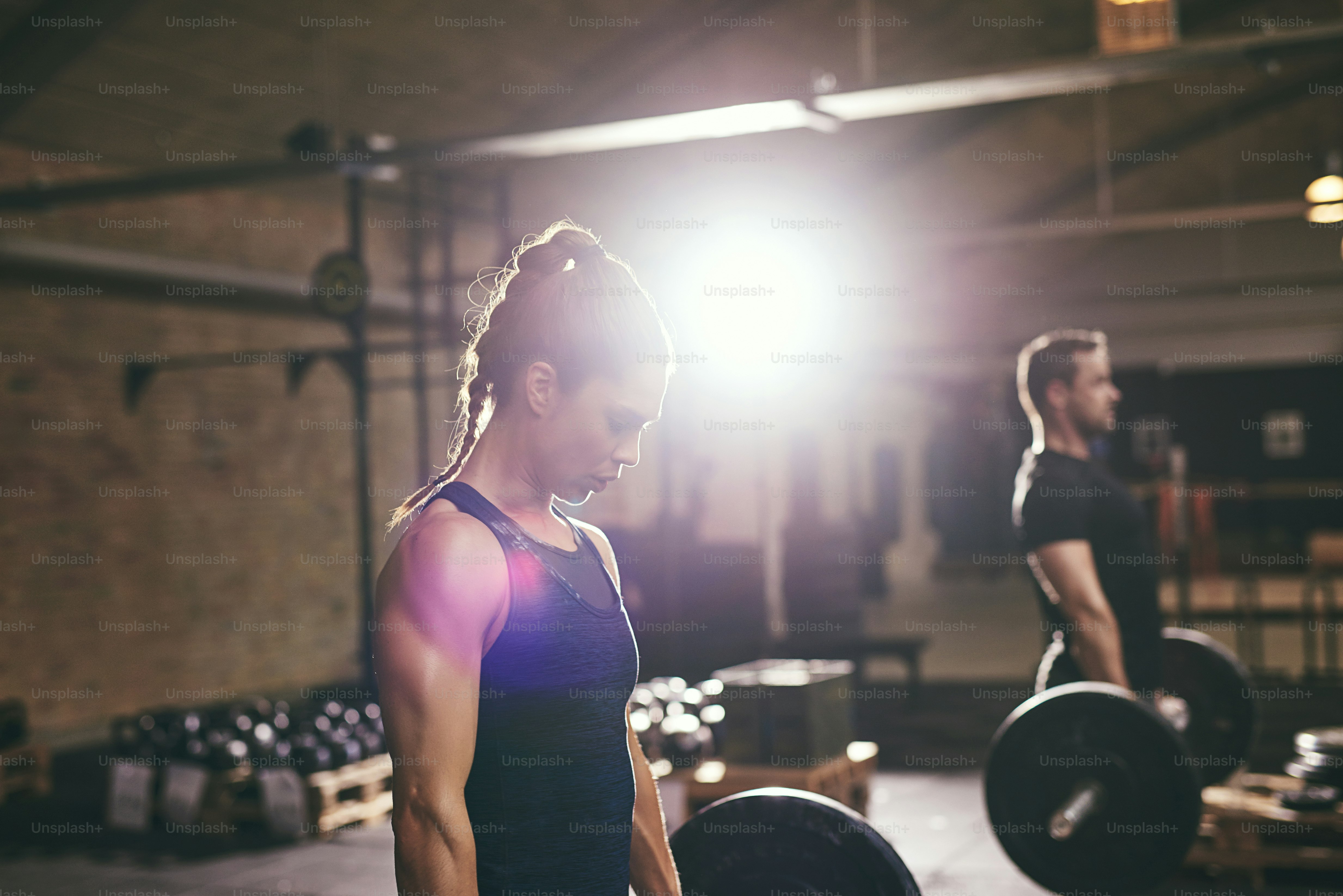 Personas sosteniendo pesas pesadas en el gimnasio. Plano horizontal en ...