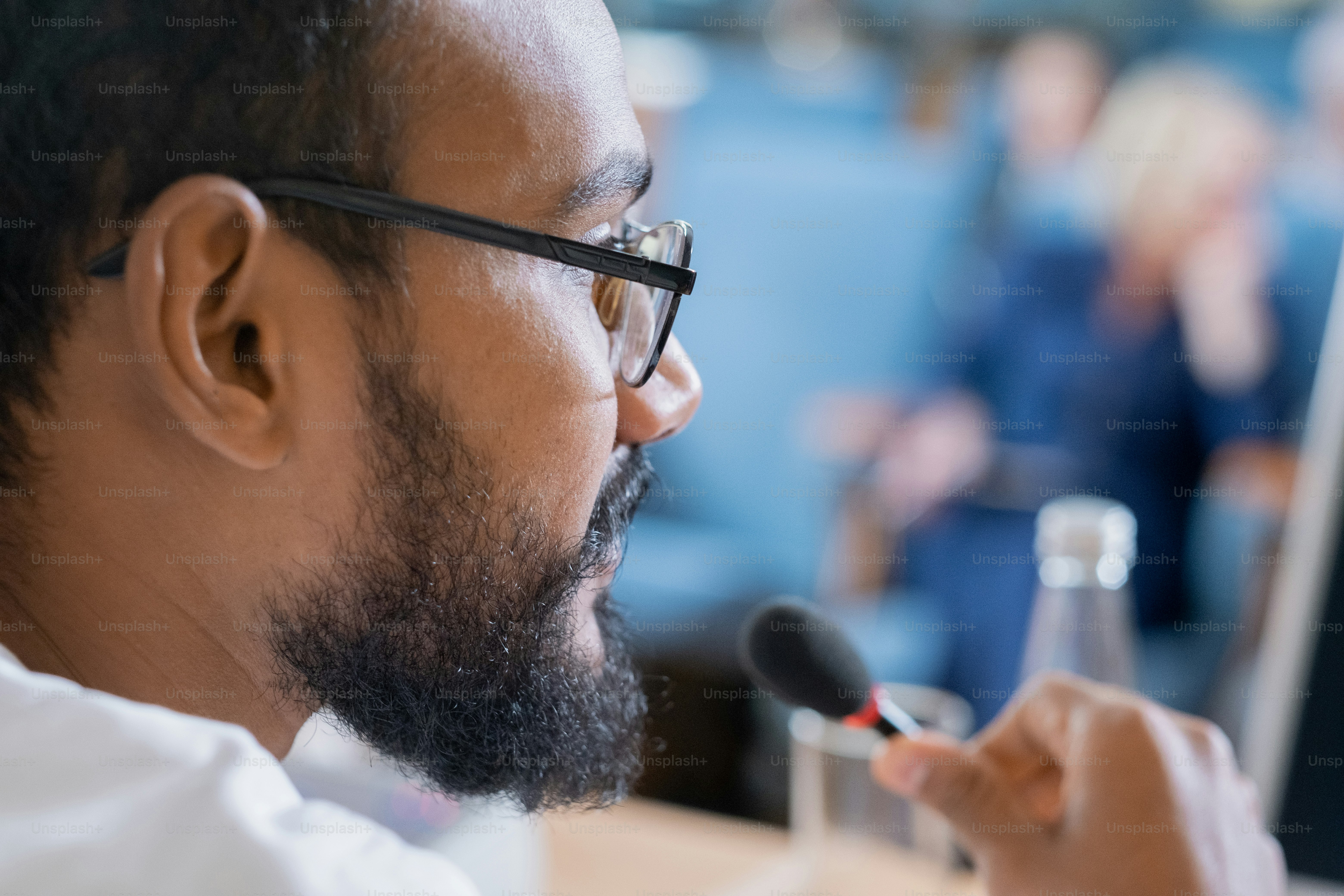 Part of face of young bearded speaker in eyeglasses making speech in ...