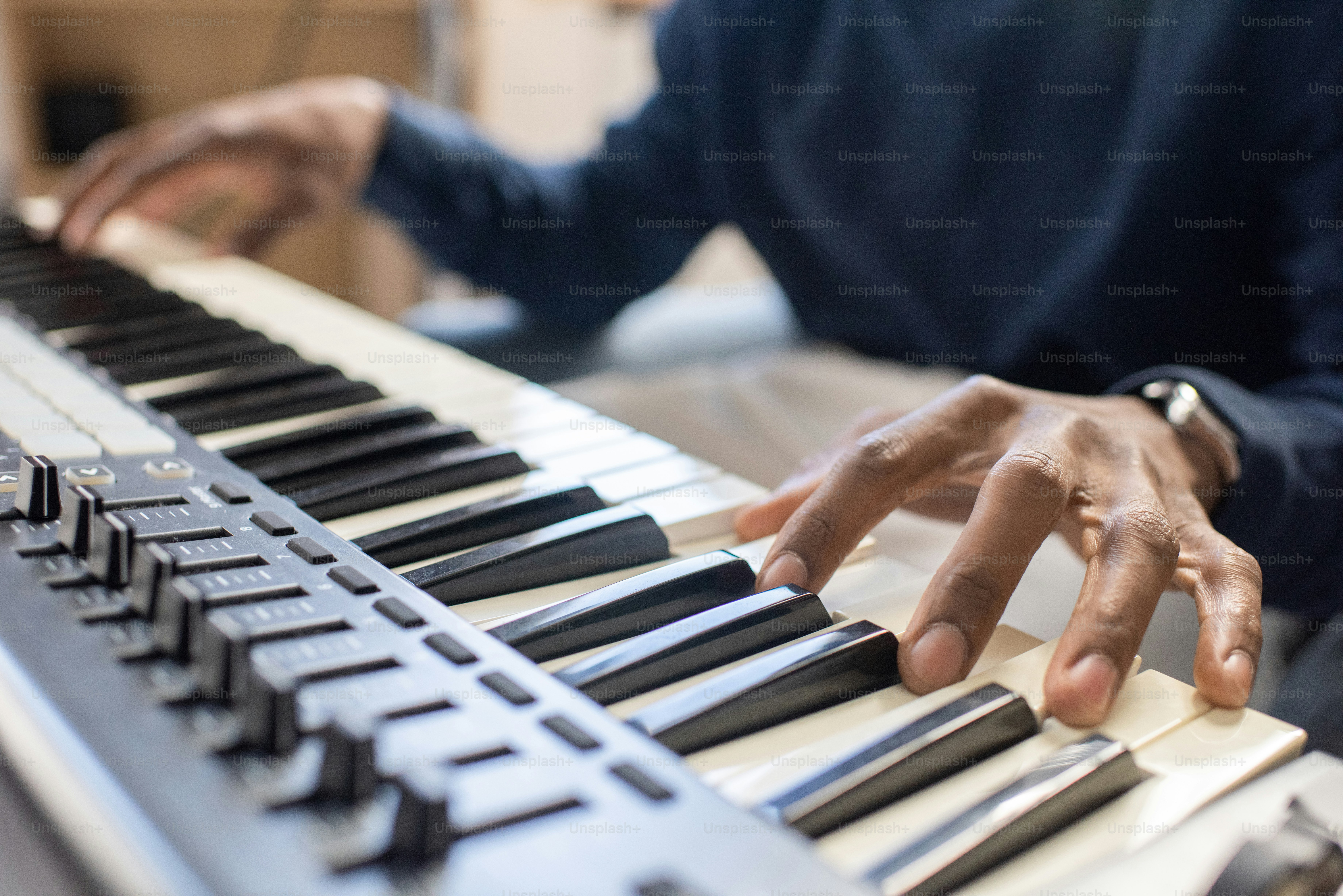 Fingers of young African man pressing keys of piano keyboard while ...