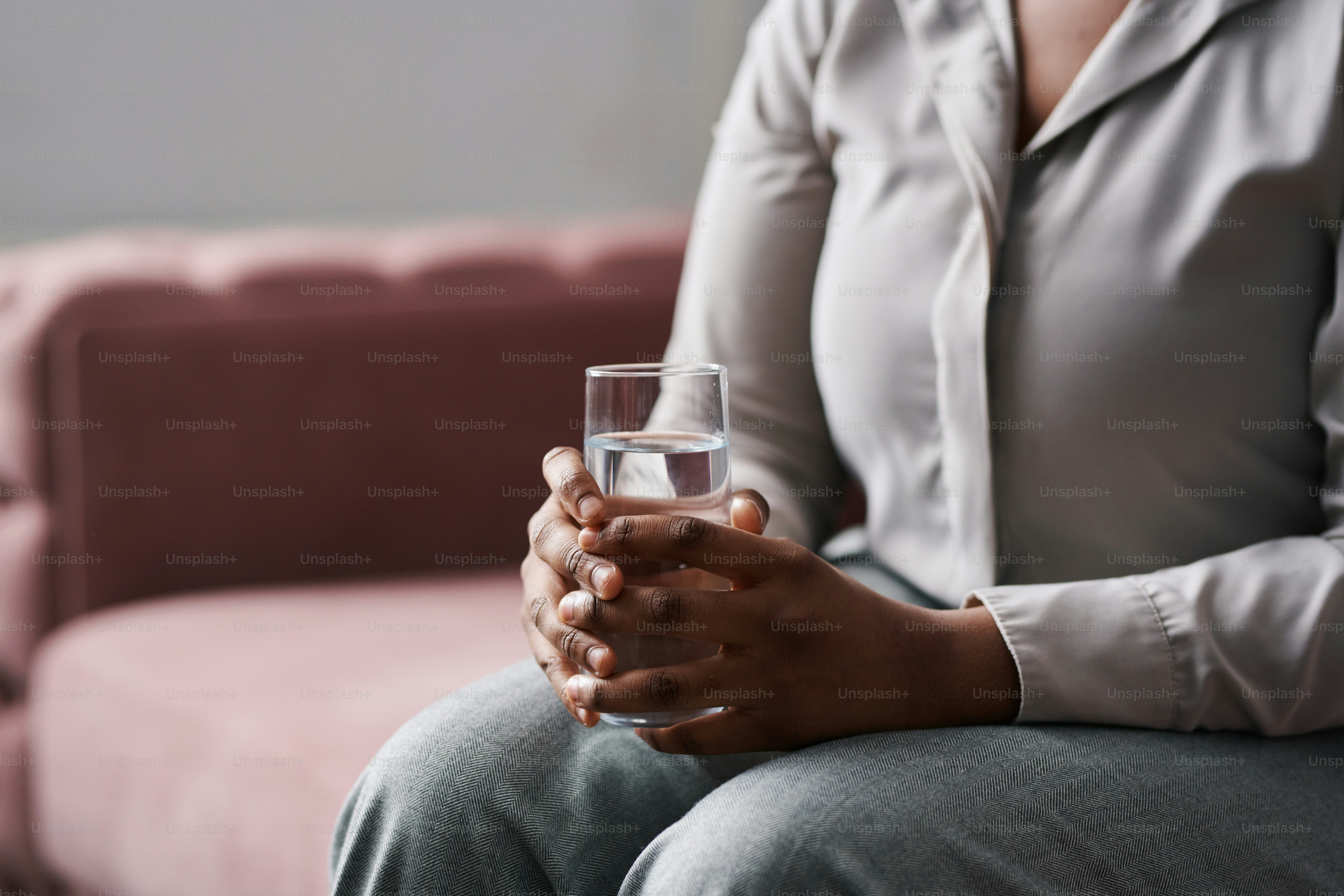 Hands of young worried female patient of counselor holding glass of ...