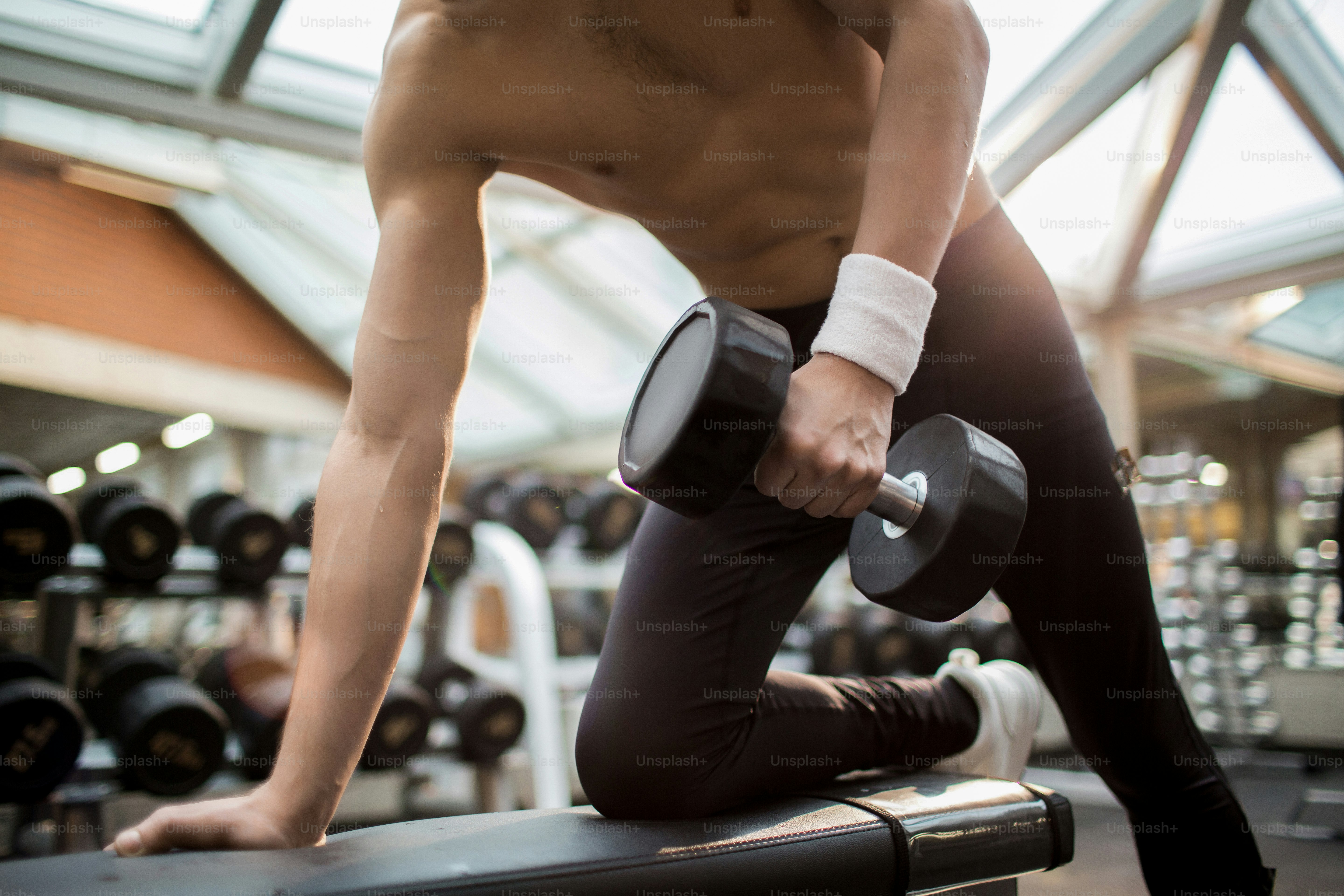 Foto Chico sin camisa con mancuernas pesadas entrenando los músculos de ...