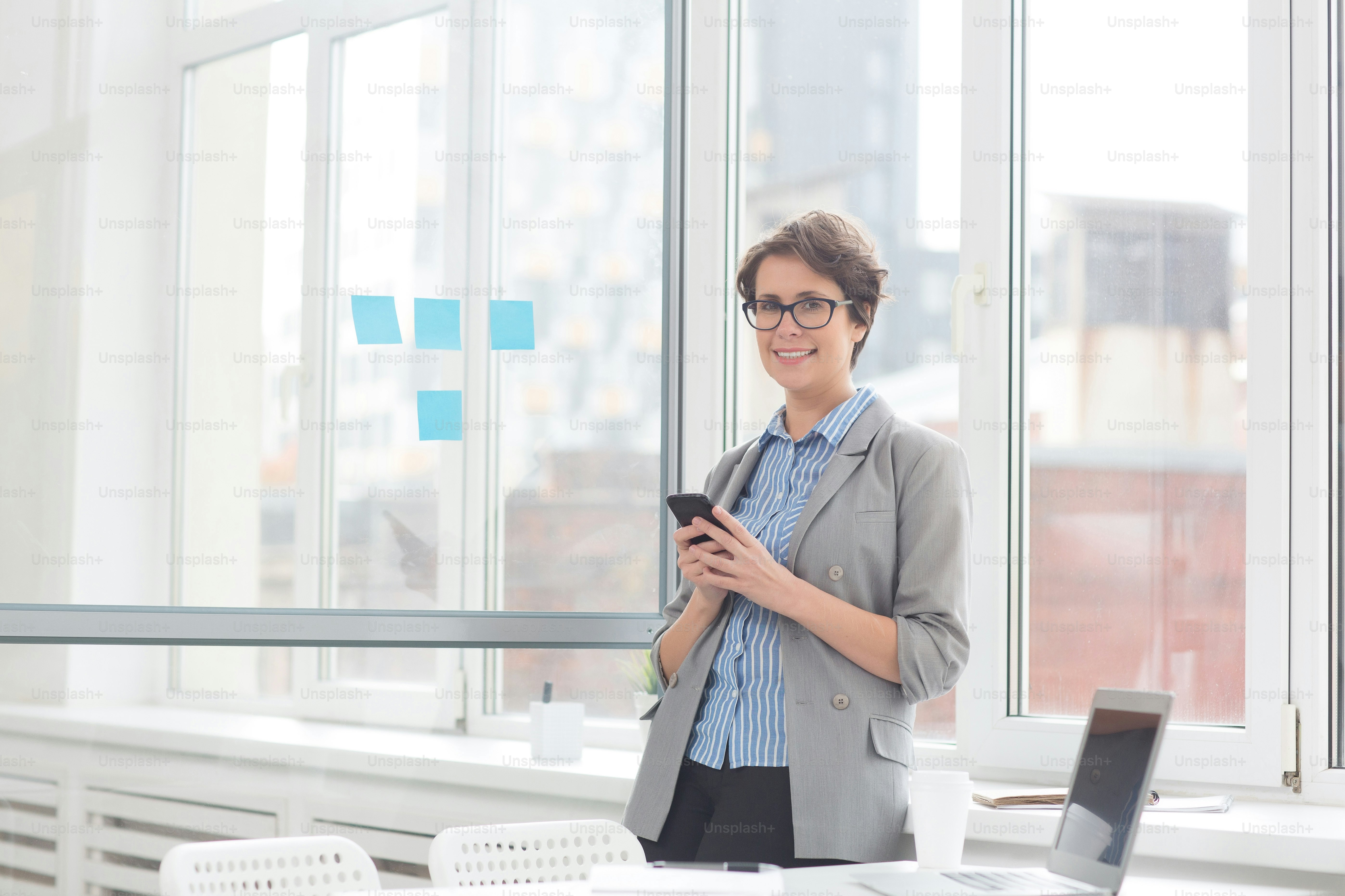 Contemporary accountant in formalwear standing by office window and ...