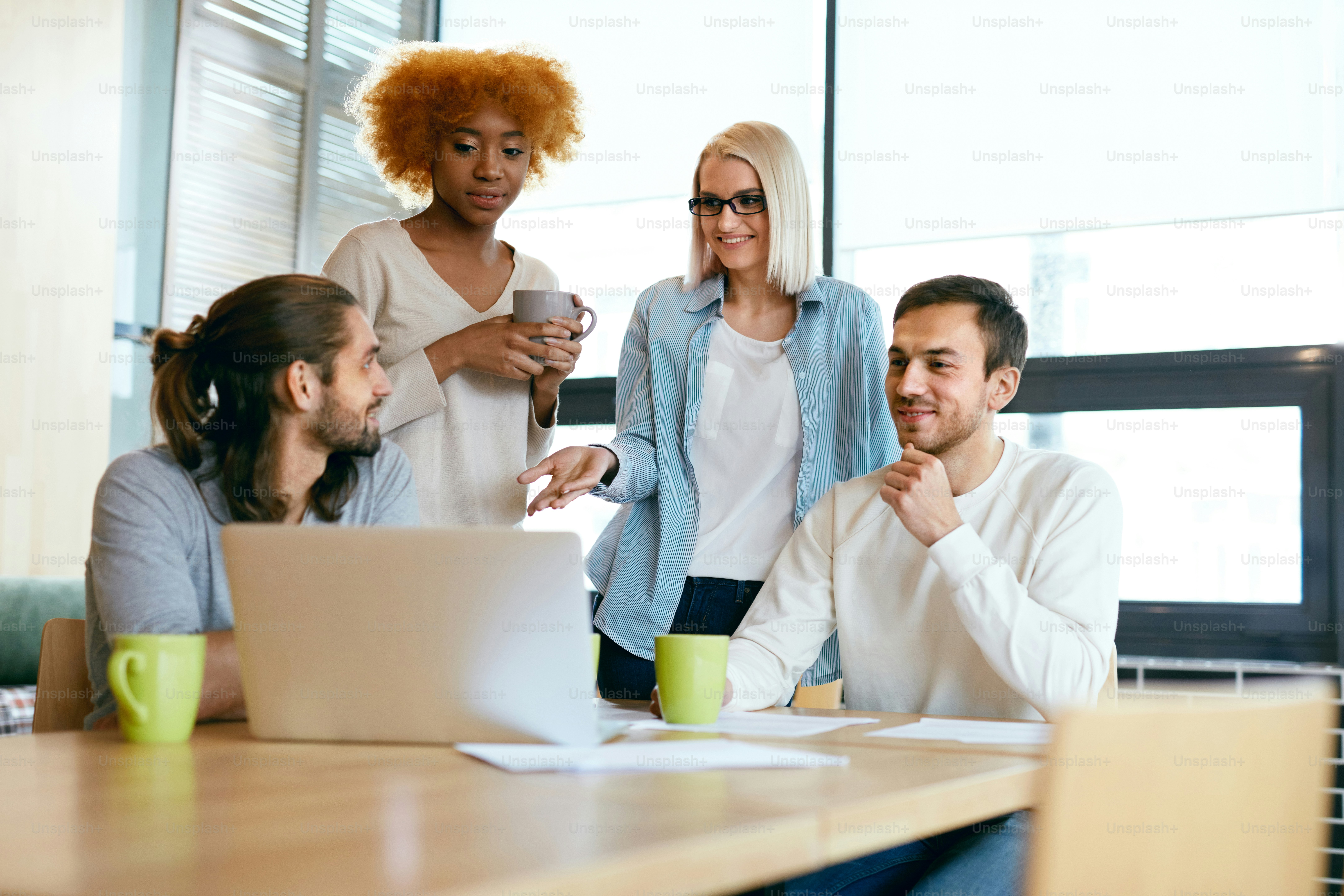 Friends Working Together At Cafe, Using Computer, Drinking Coffee And ...