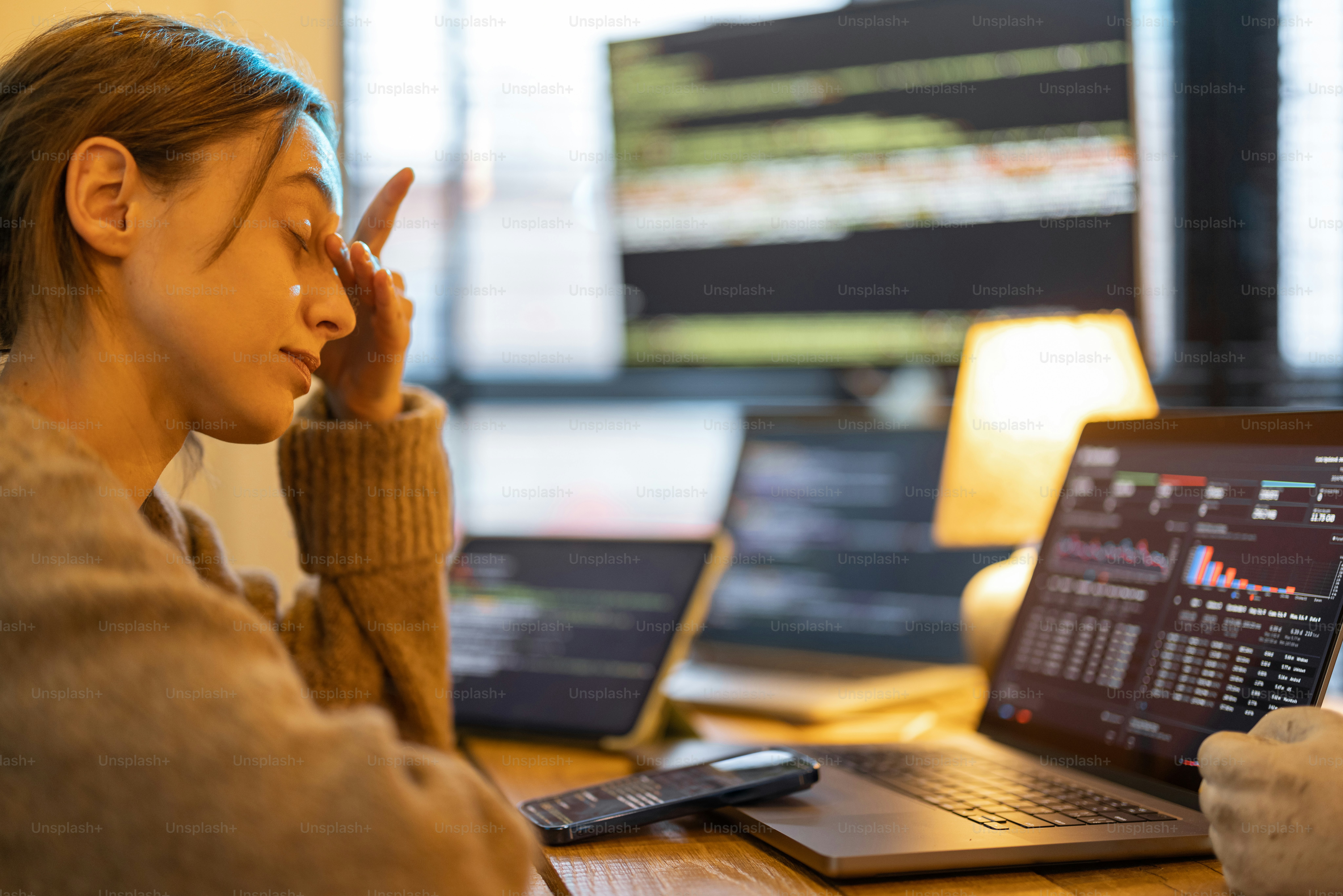 Portrait of tired overworked woman sitting at workplace with computers ...