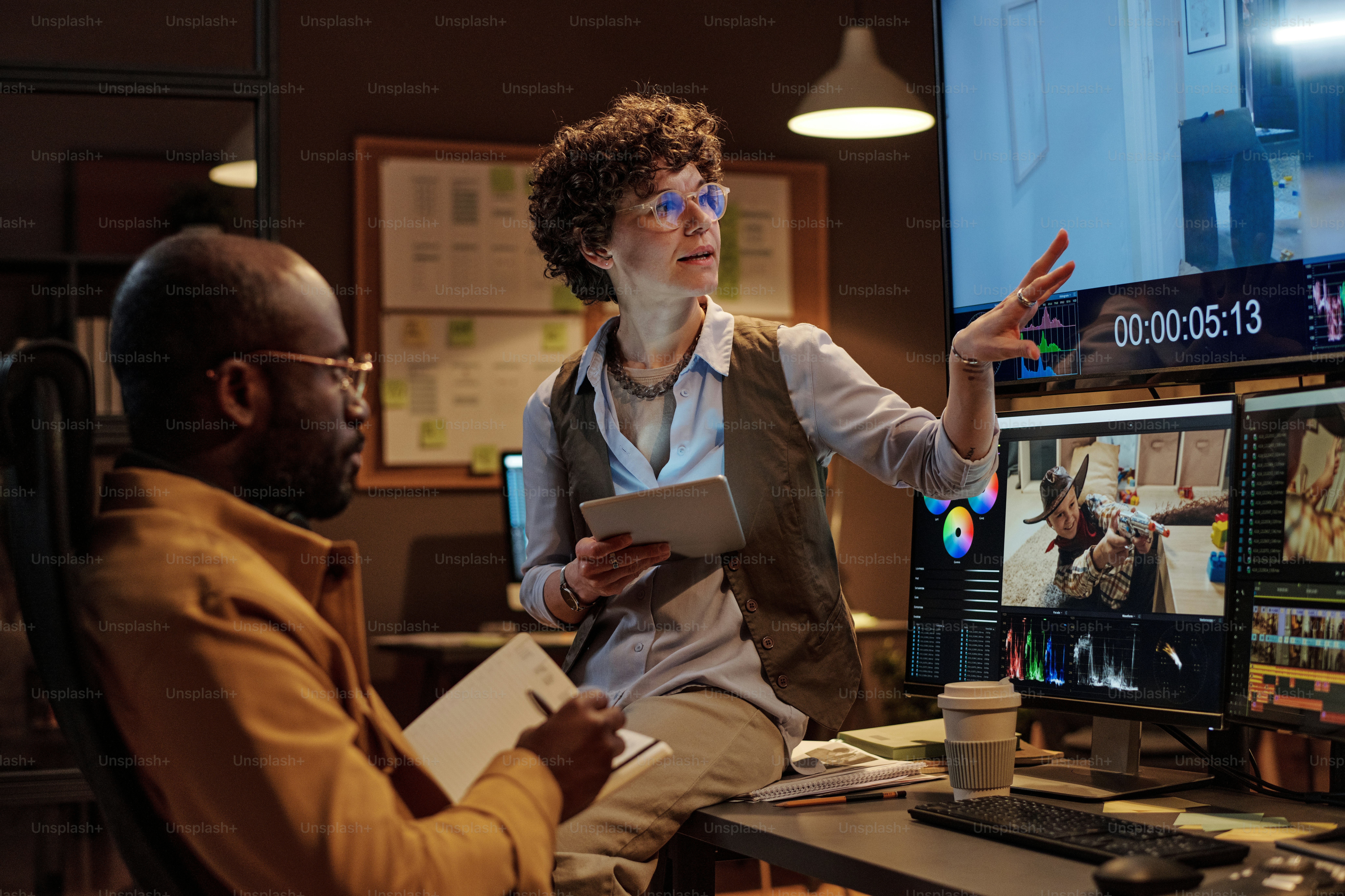 Young project manager pointing at big screen and explaining the idea of ...