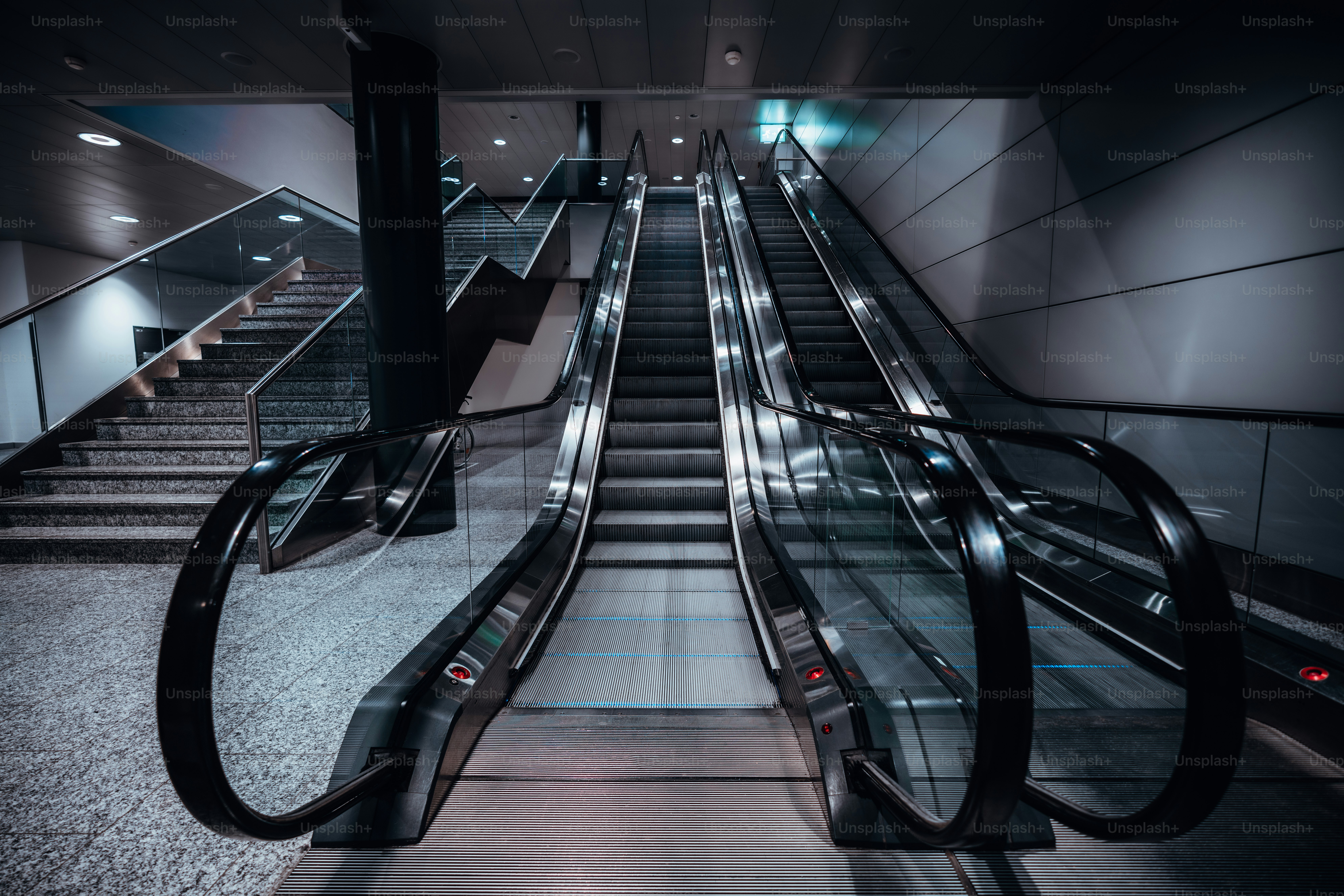 A frontal wide-angle shot of two escalators in a shopping mall or an ...