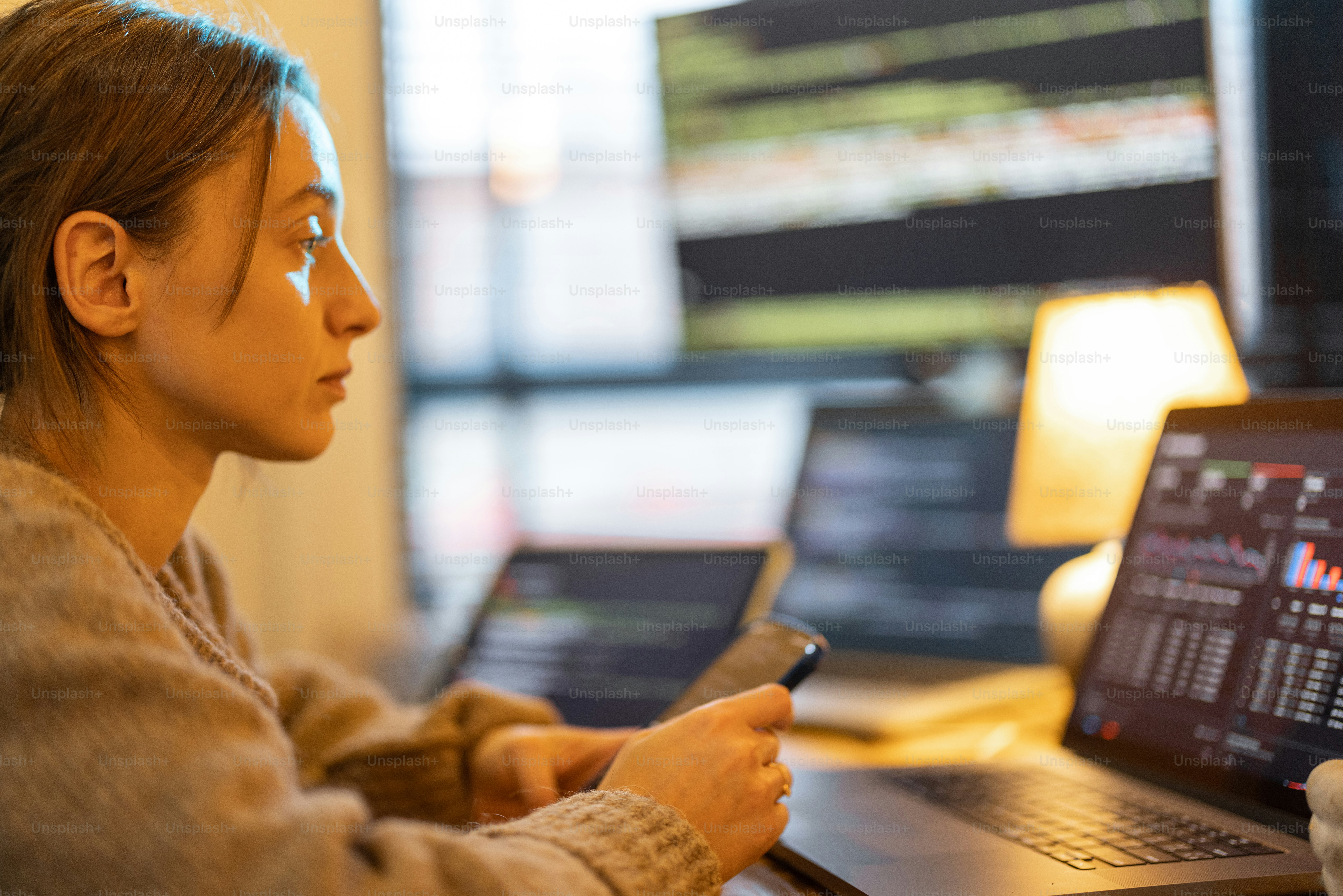 Young woman works on computers, sitting at workplace at cozy home ...