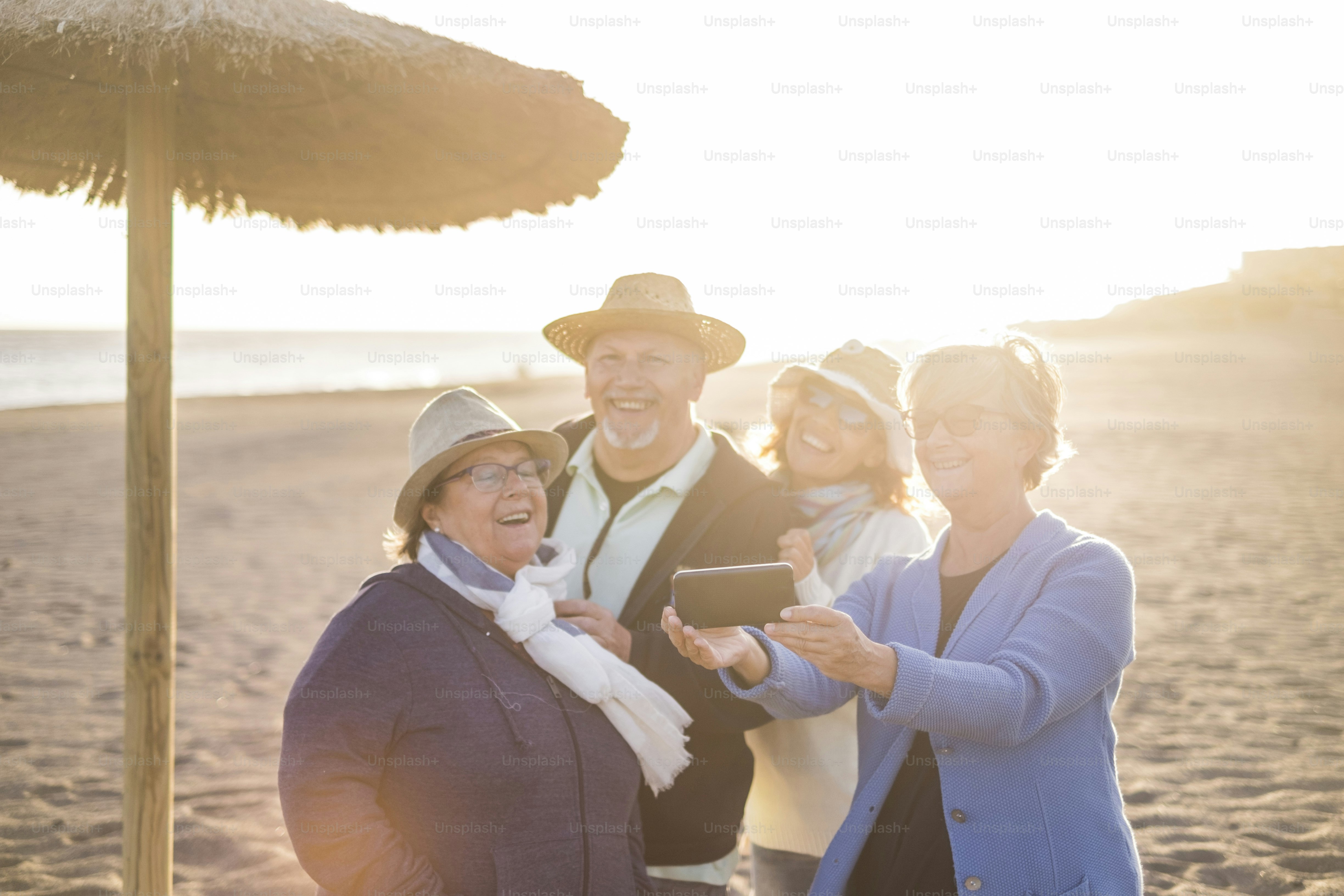 Elderly senior group of friends with a 40s woman having phone at the ...