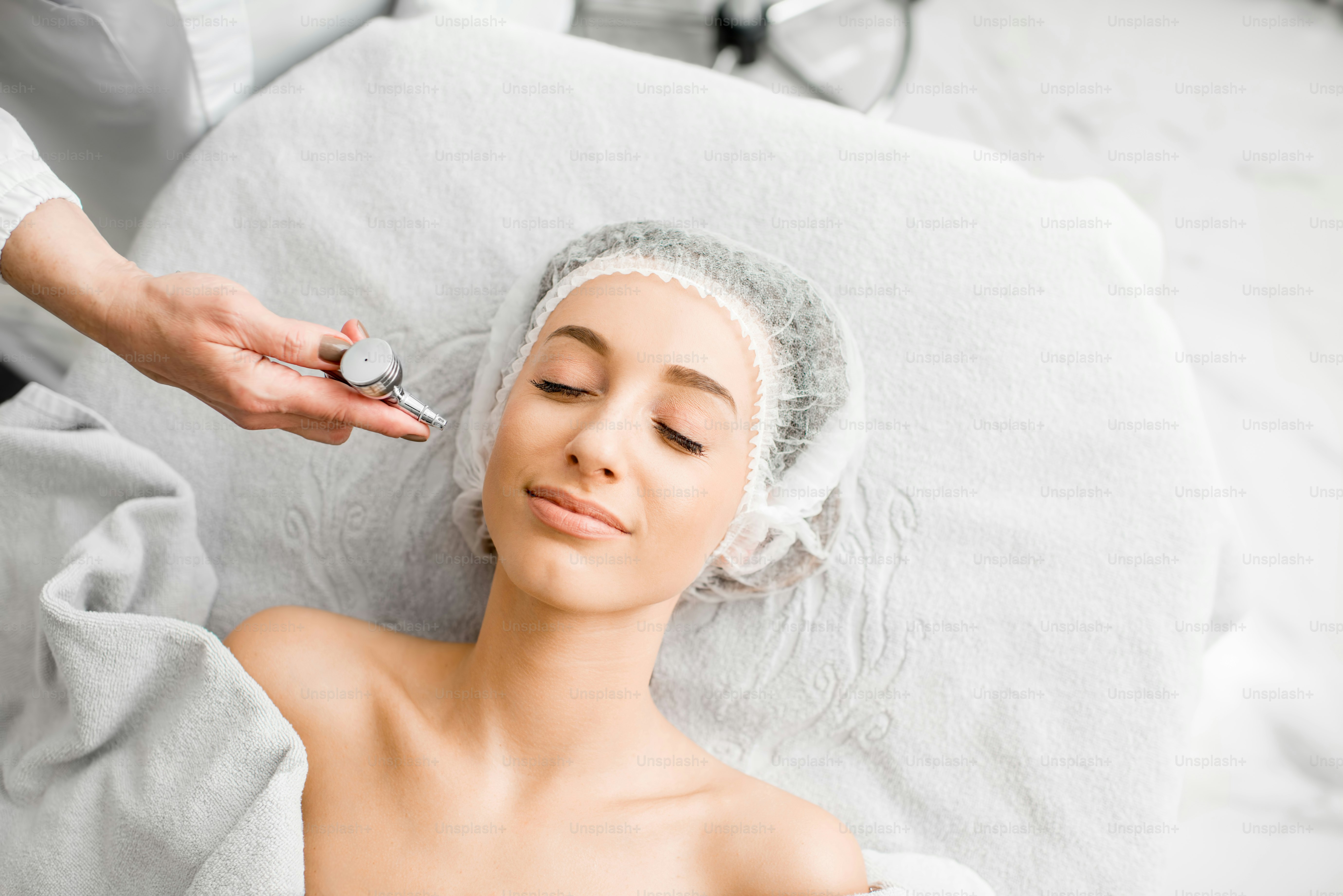 Young woman during the professional hydration procedure on the face in ...