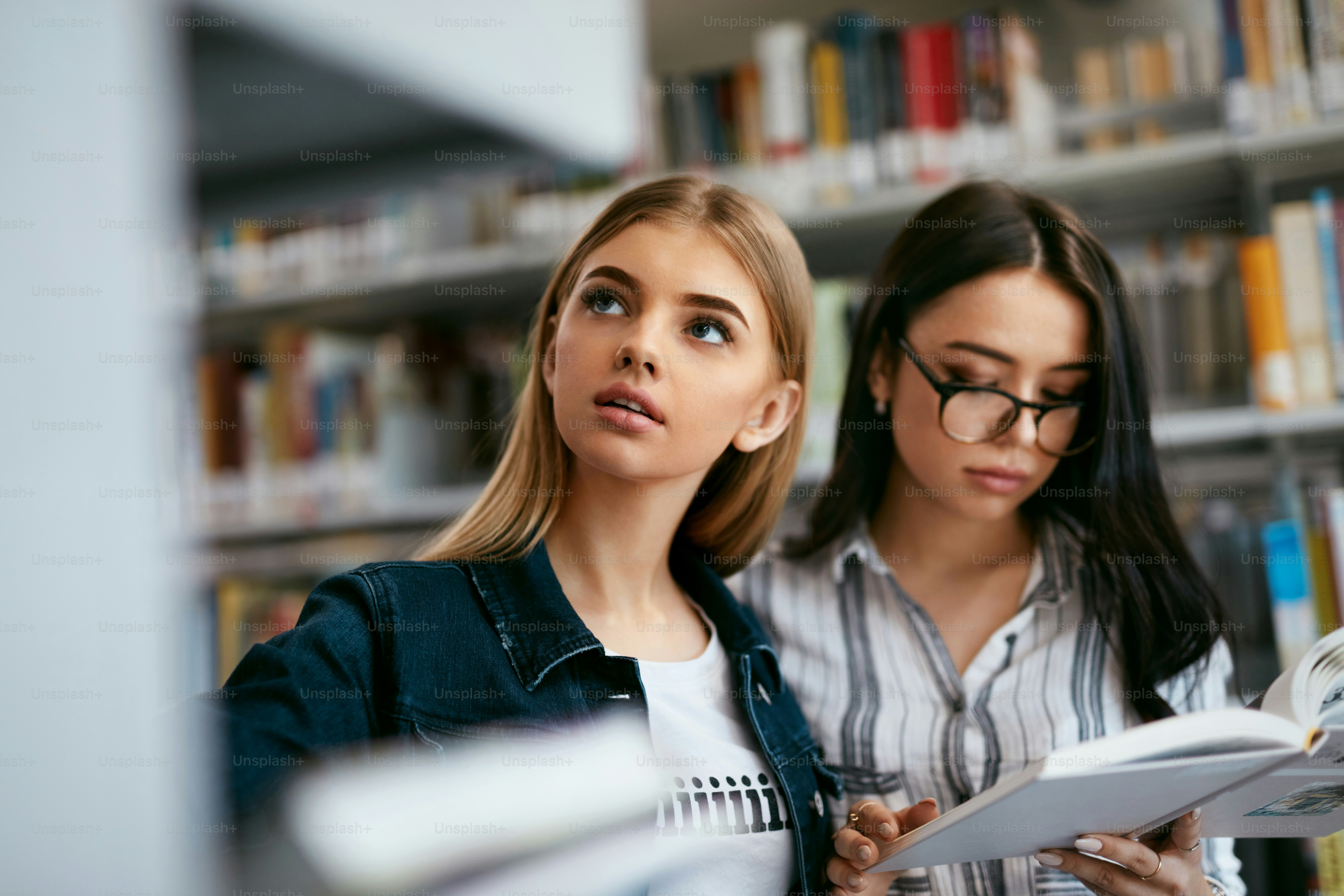 Students Studying In University Library. Man And Woman Reading Books ...