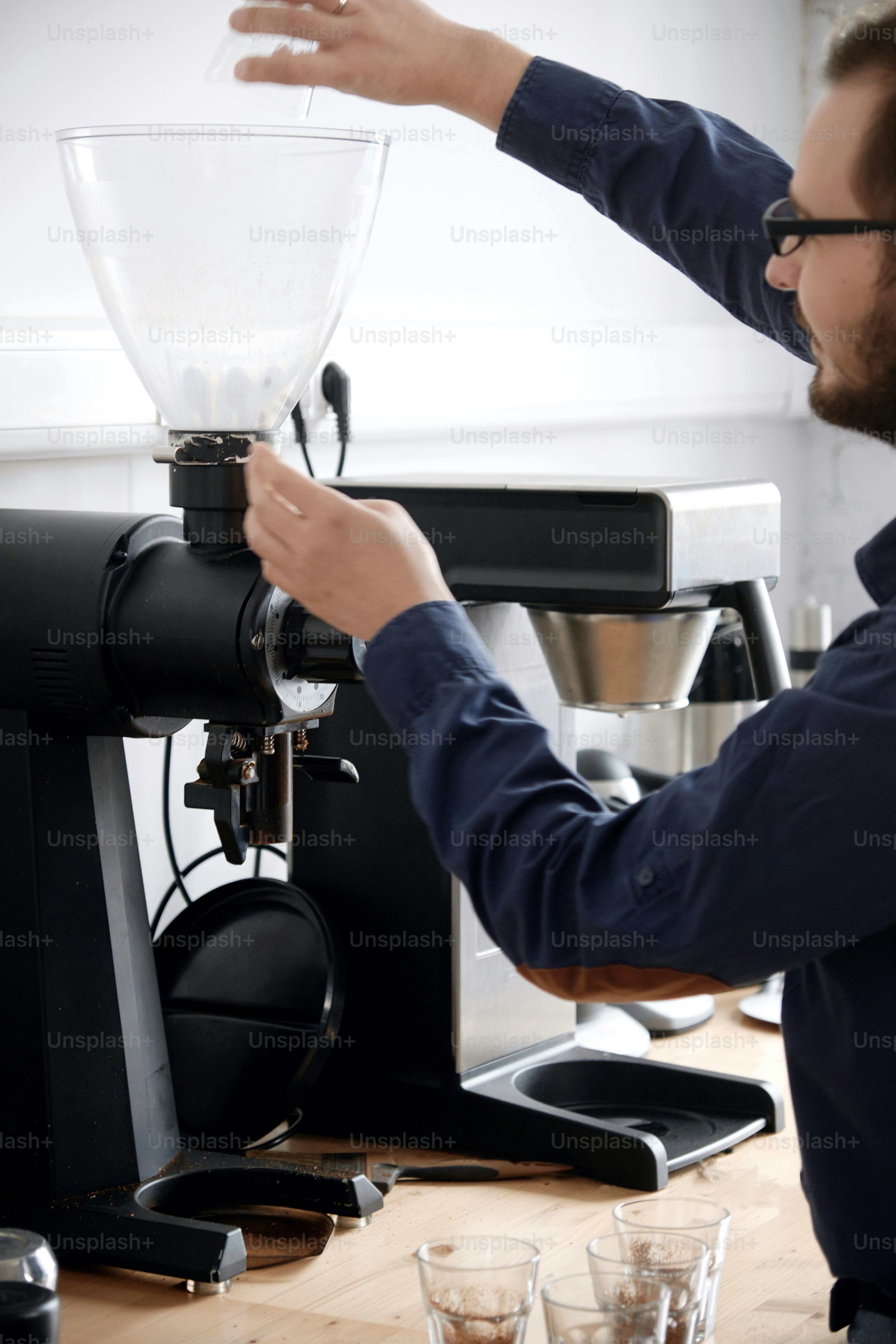 Close up of man using coffee machine, grinding coffee beans into cups ...