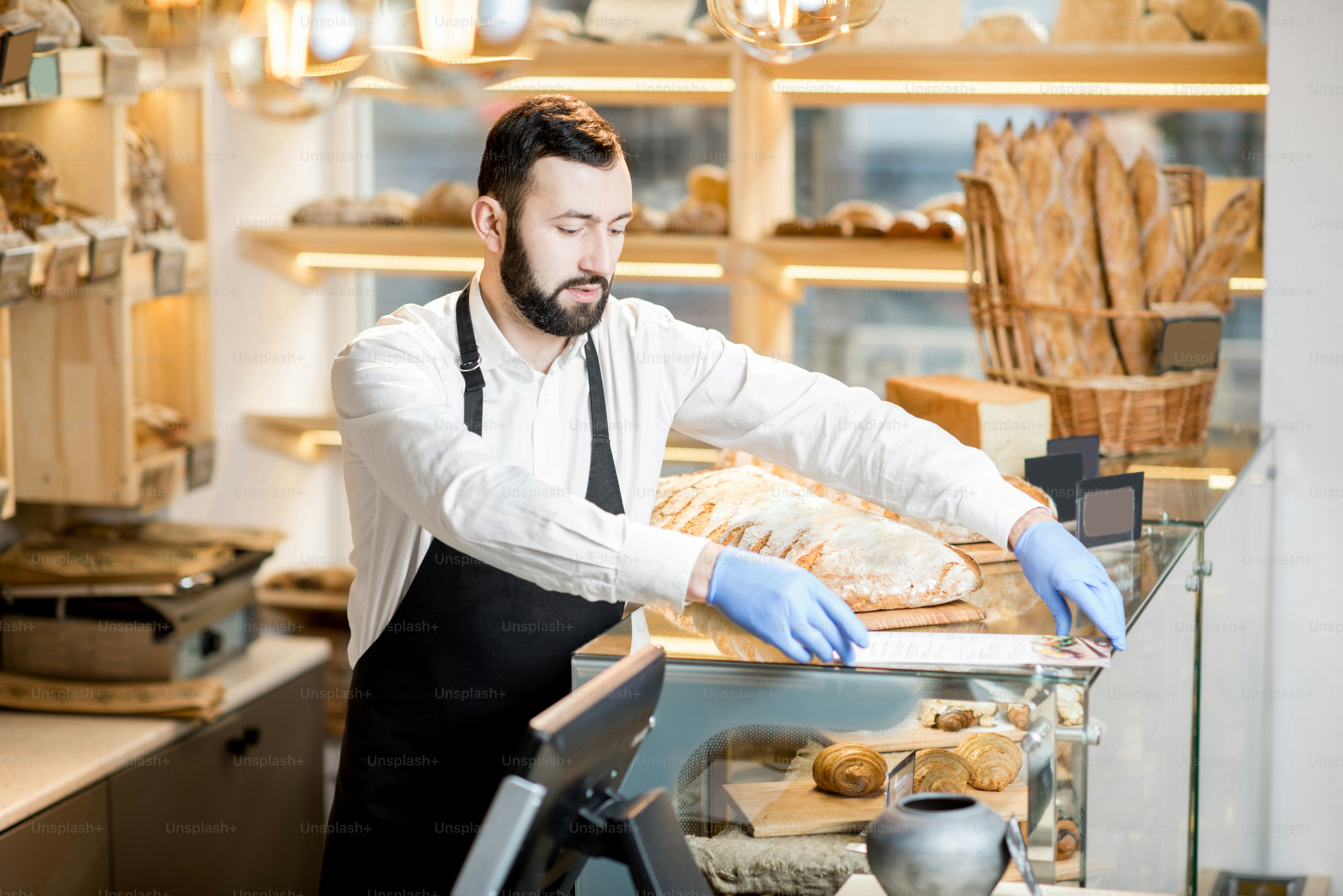 Bread seller working in the small and beautiful store with bakery ...