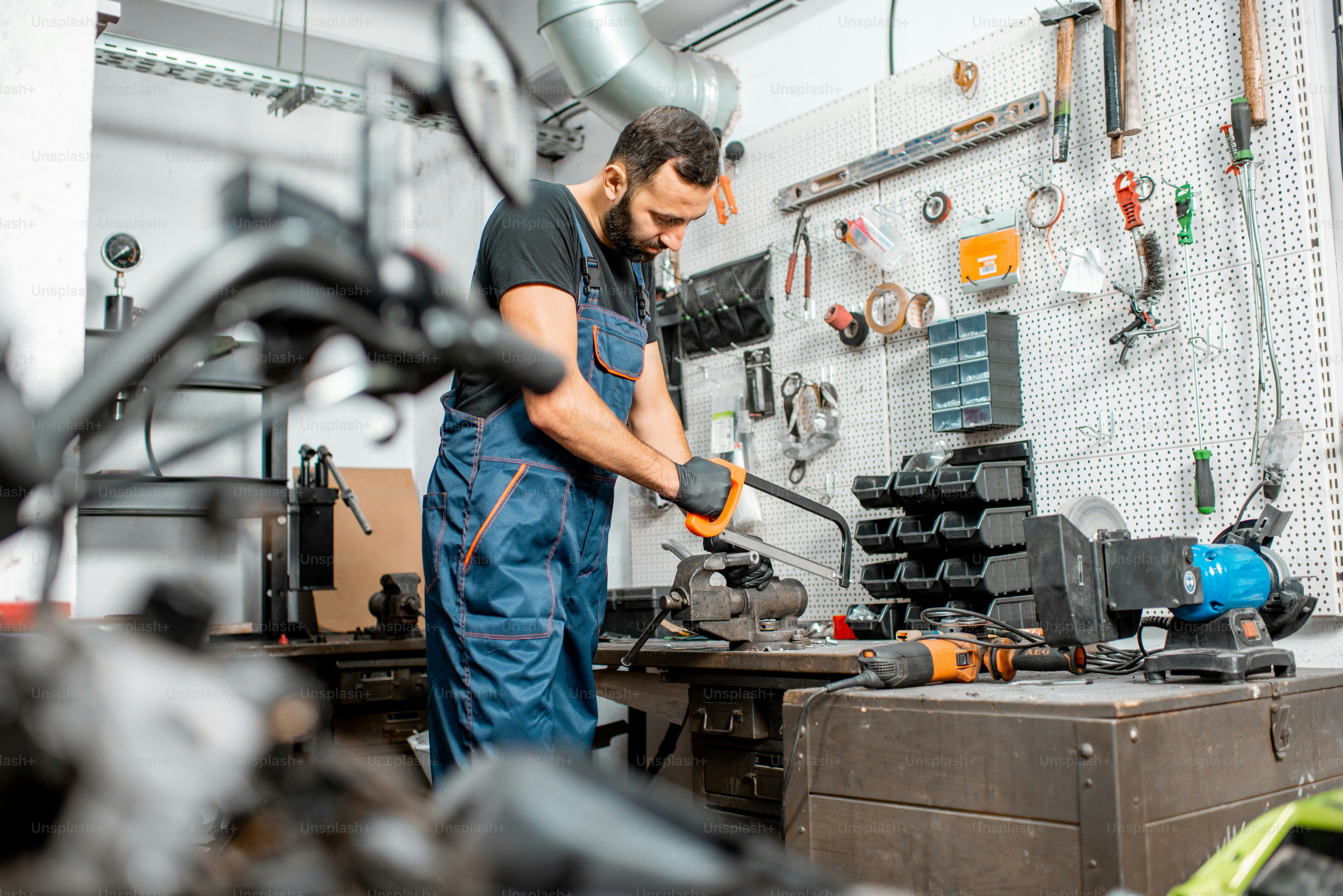 Foto zum Thema Handwerker im Overall bei der Arbeit am Arbeitsplatz mit ...