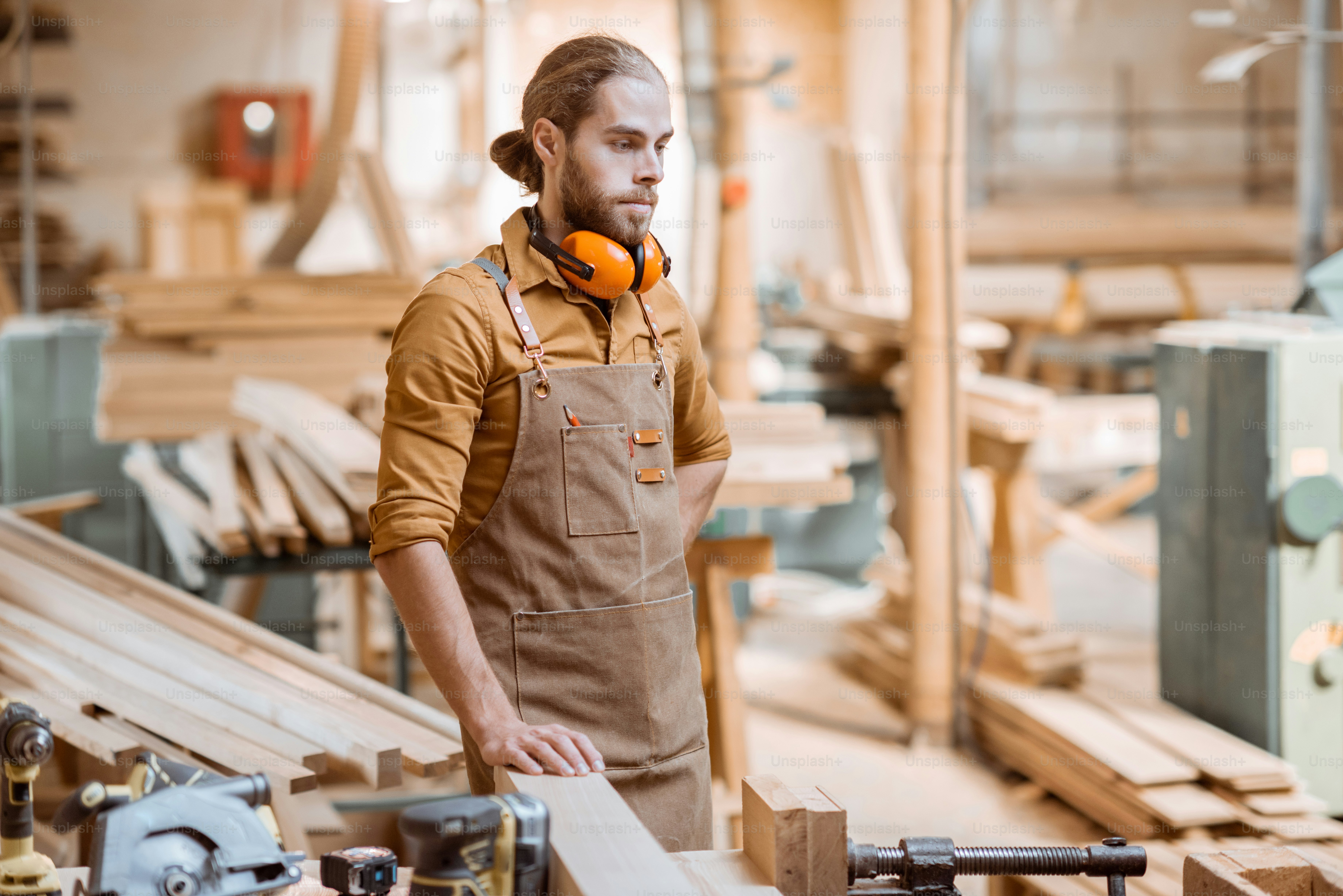 Portrait of a creative carpenter with headphones at the workshop photo ...